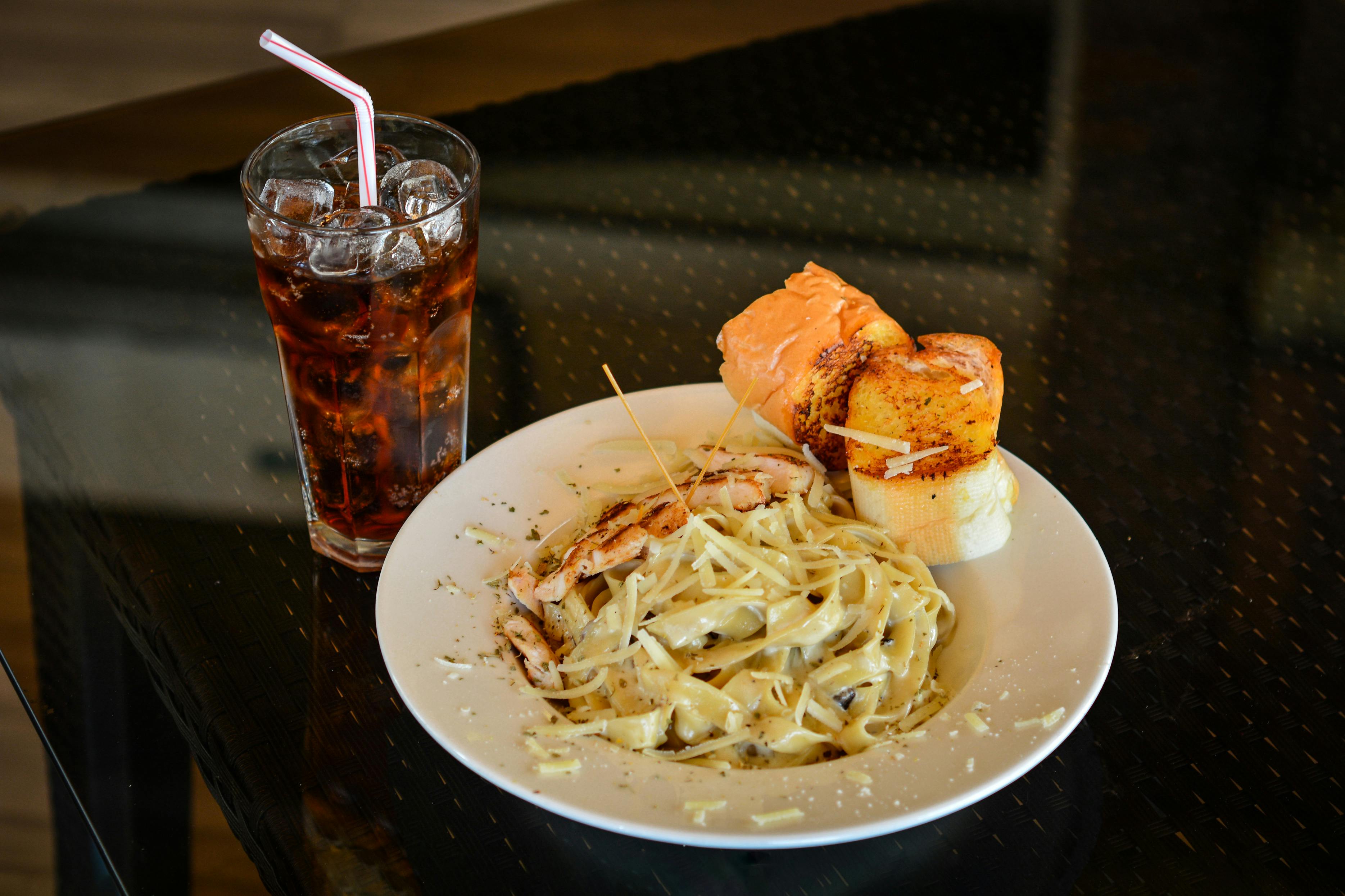 Close-Up Shot of a Plate of Pasta beside a Glass of Soft Drink · Free ...