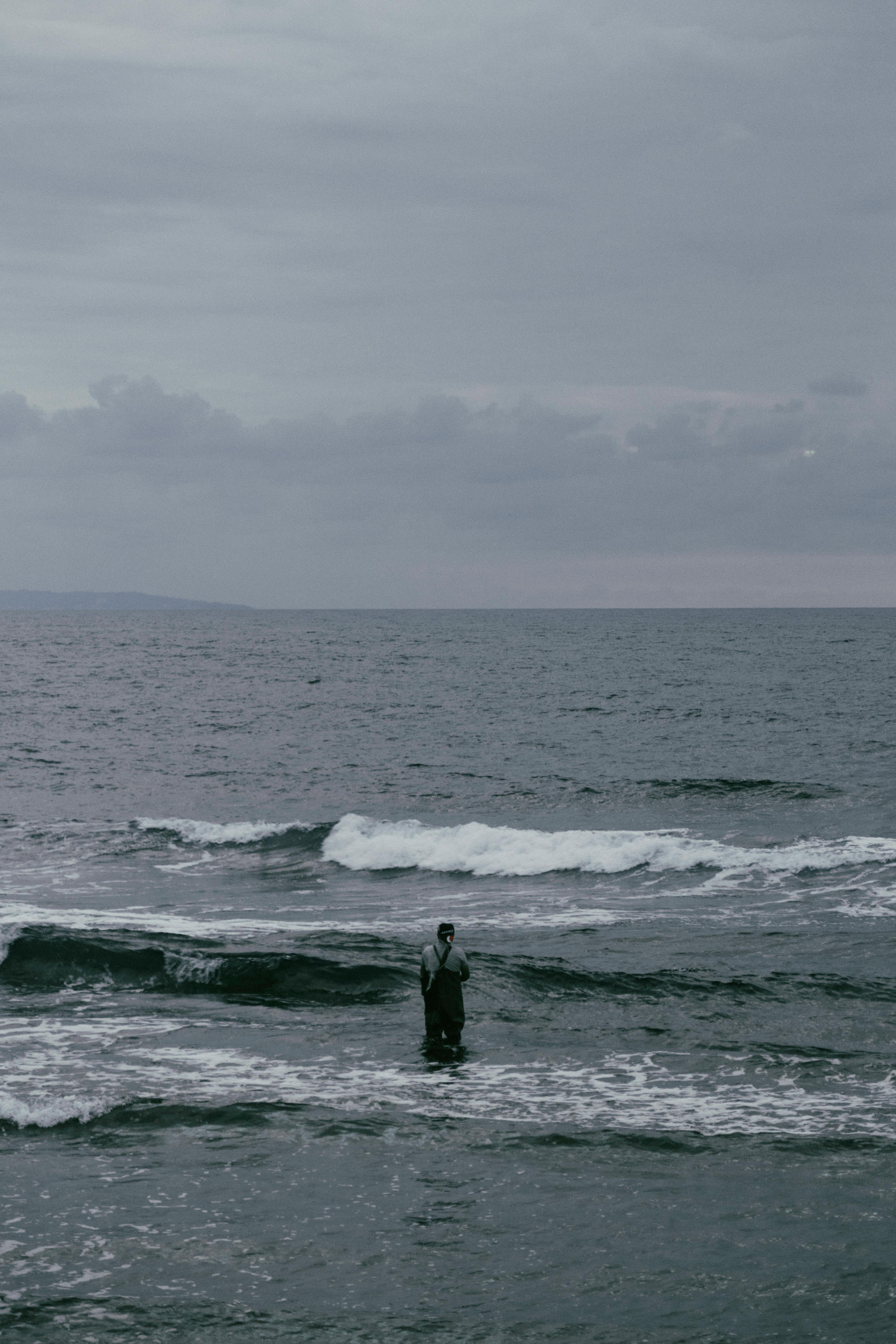 Person Standing on Sea Water · Free Stock Photo