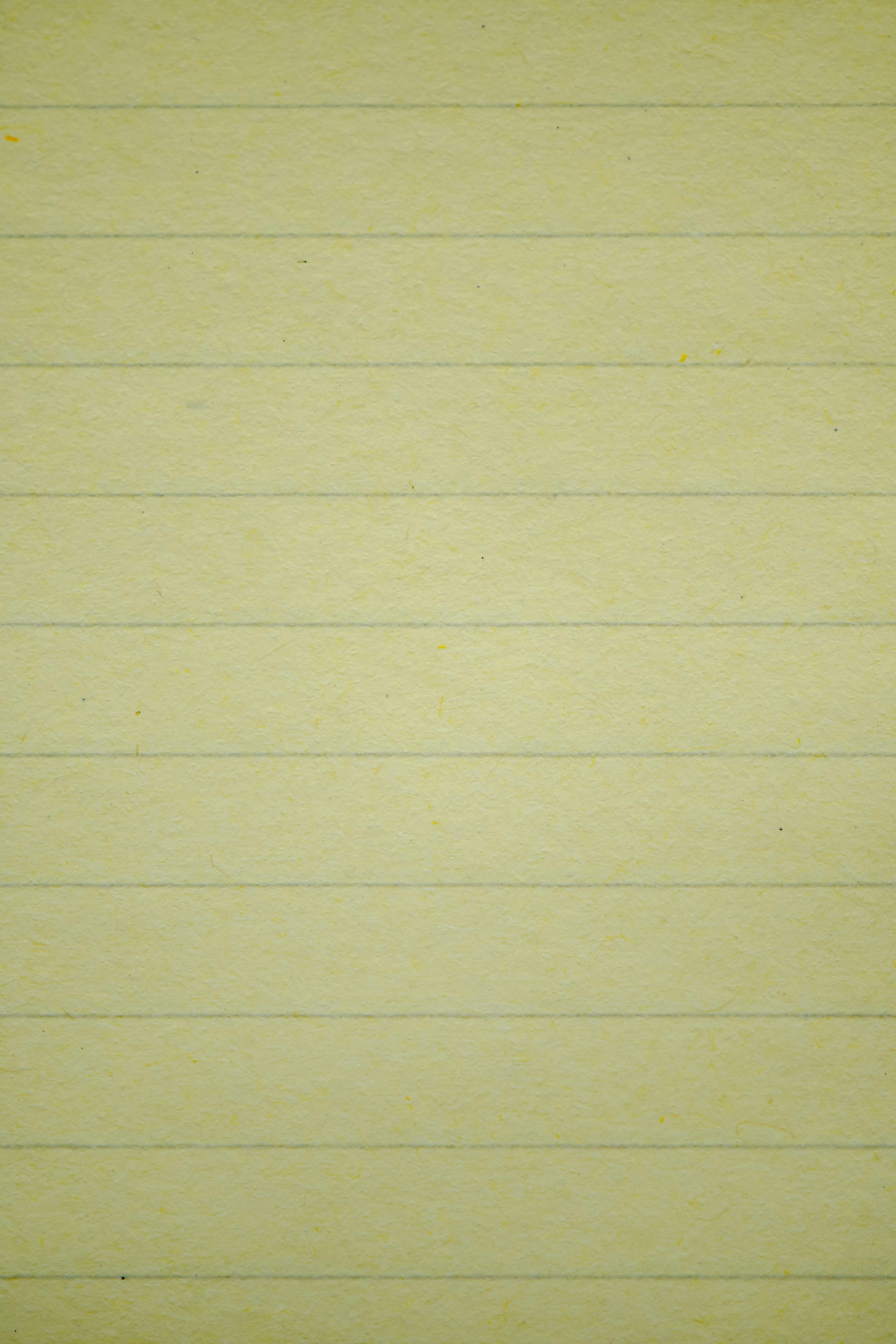 A Close-Up Shot of a Yellow Pad Paper · Free Stock Photo