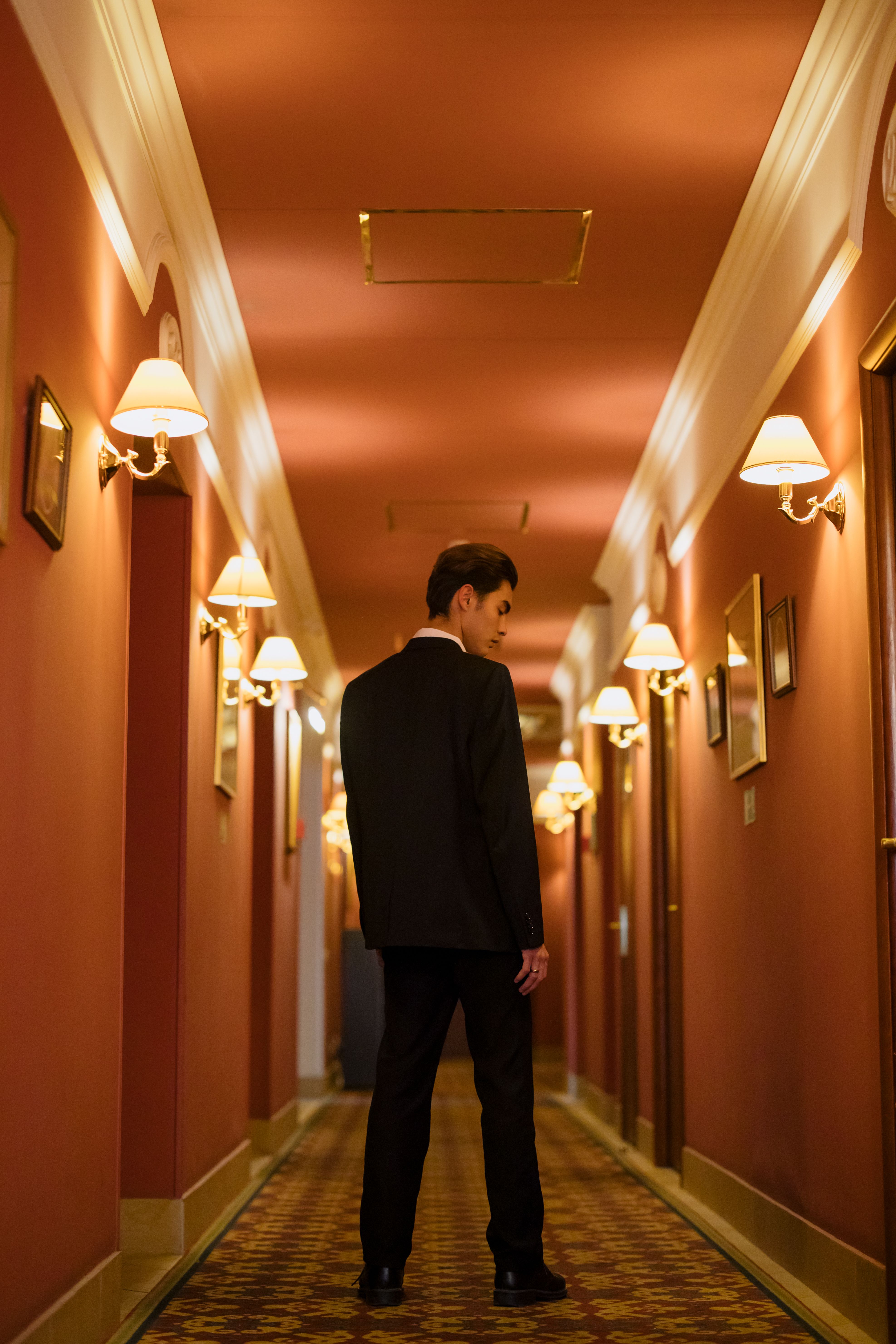 Man in Black Suit Standing in Hallway · Free Stock Photo