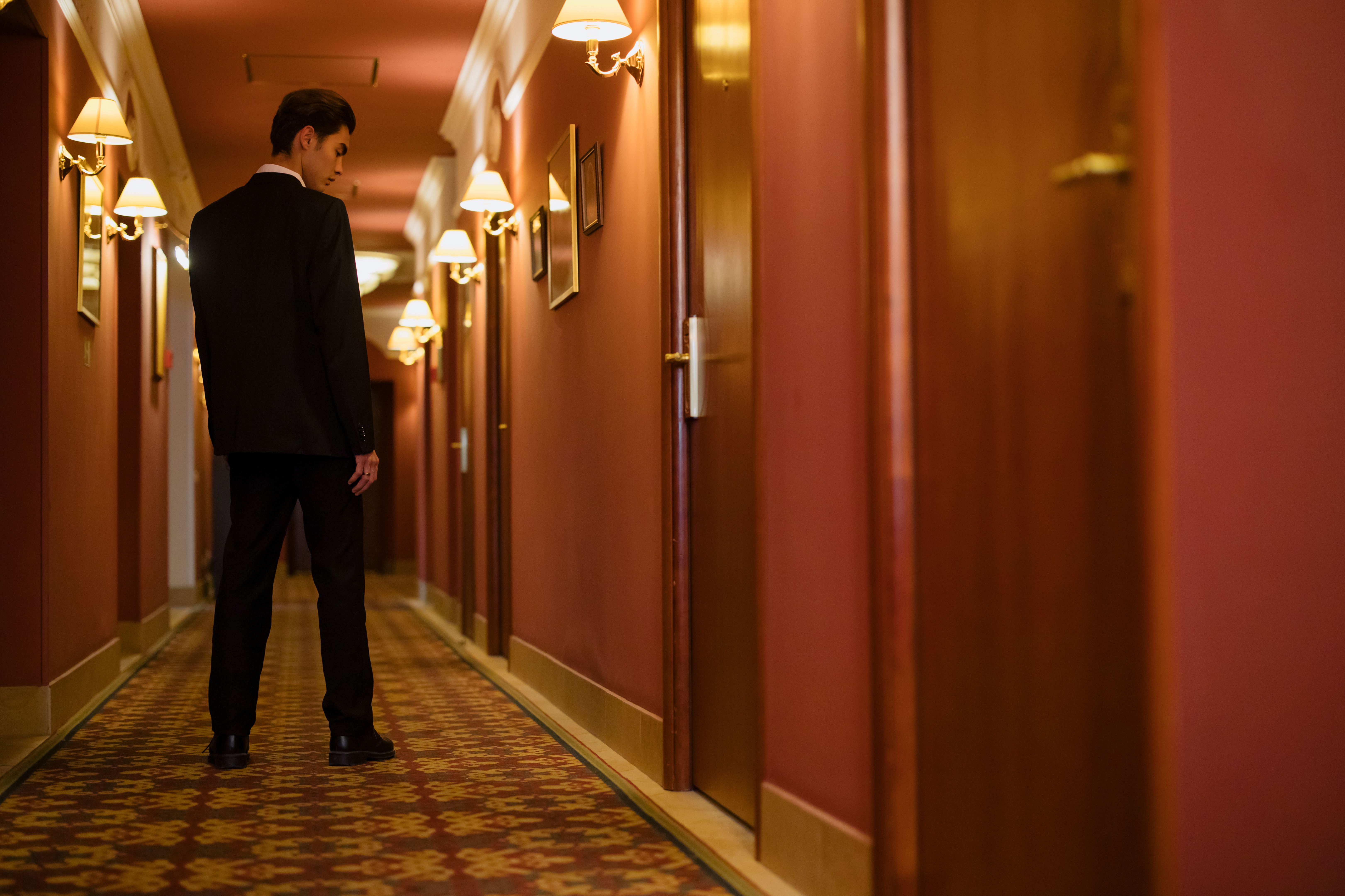 Man in Black Suit Standing in Hallway · Free Stock Photo