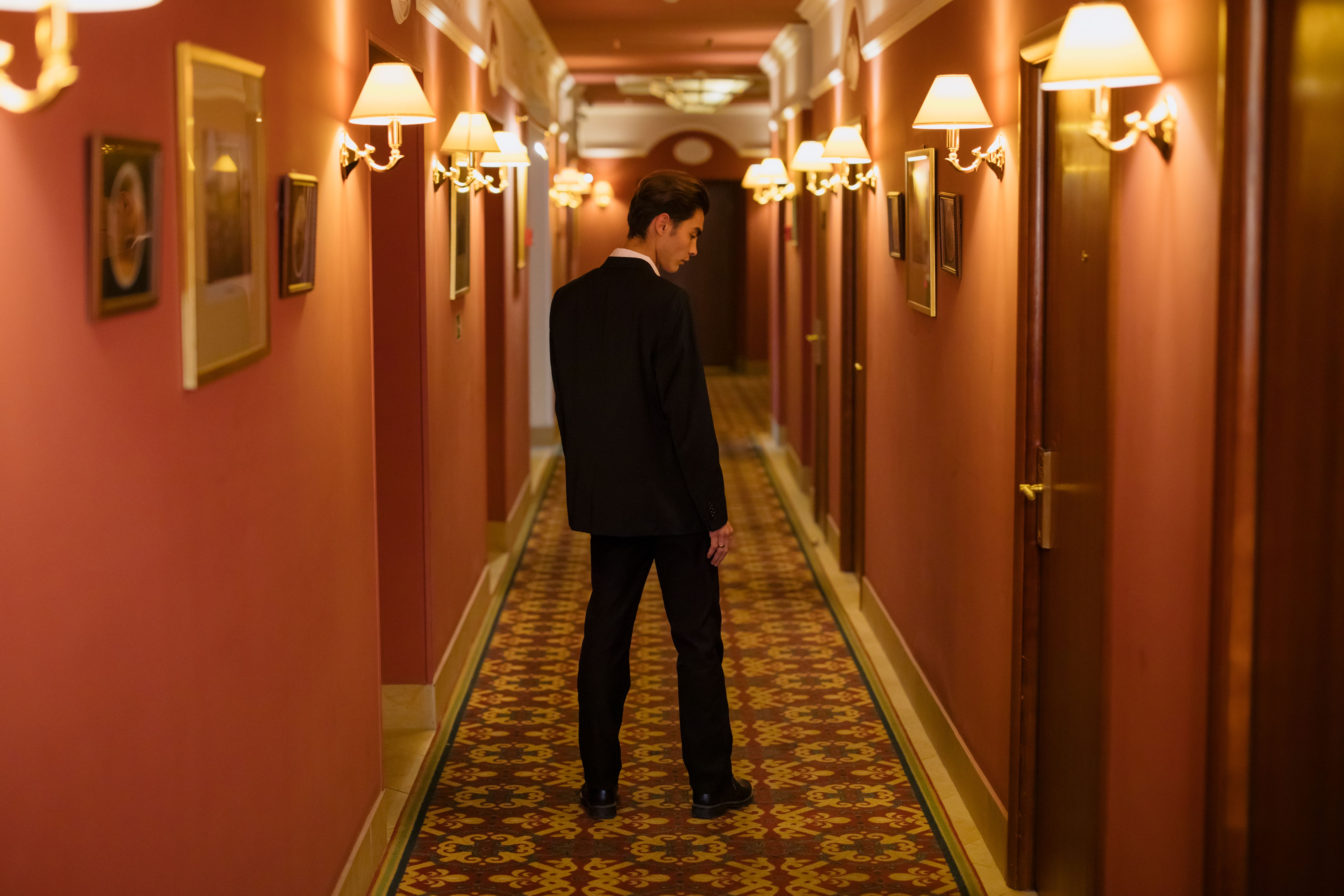 Man in Black Suit Standing in Hallway · Free Stock Photo