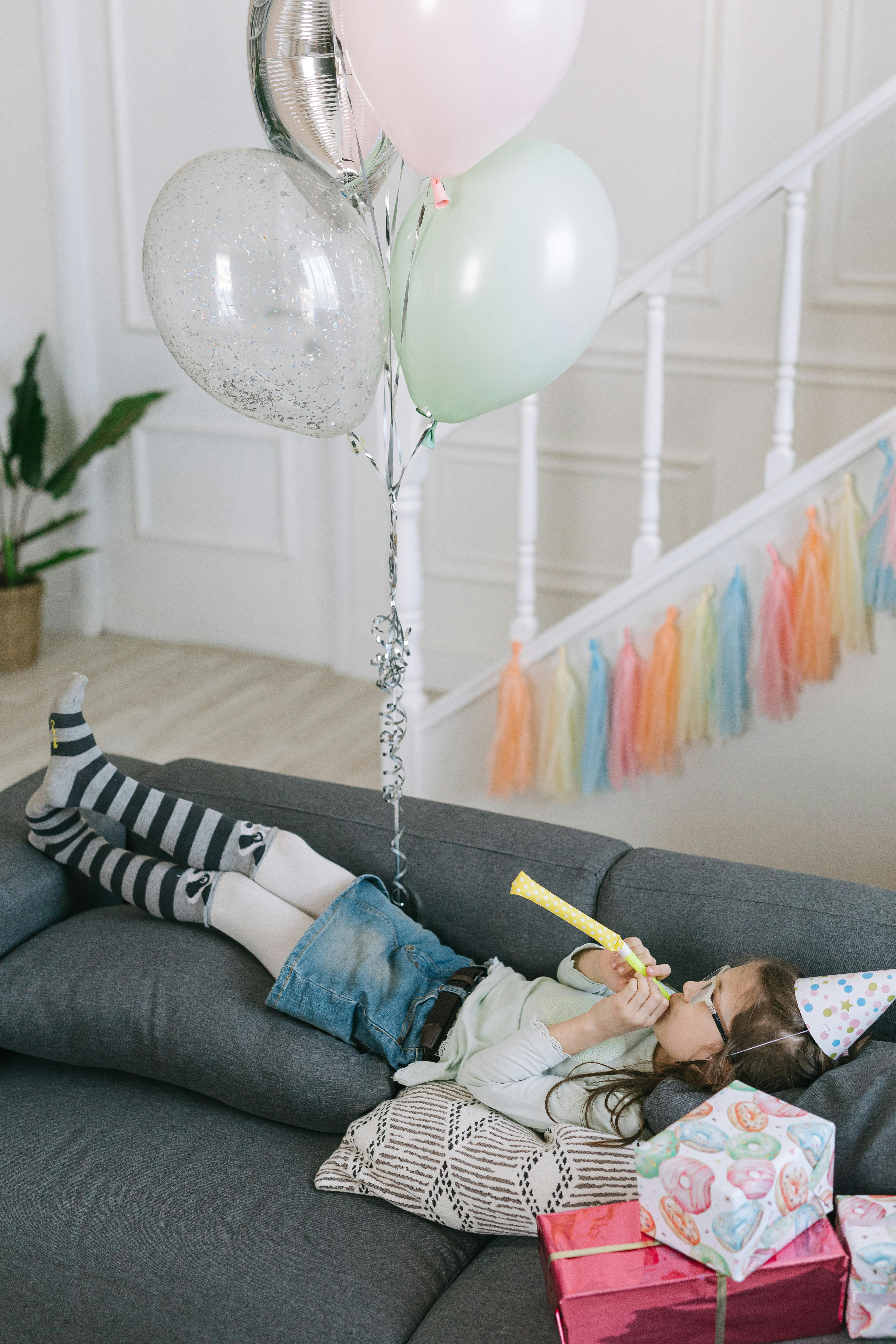 A Young Girl Lying on the Couch with Balloons · Free Stock Photo