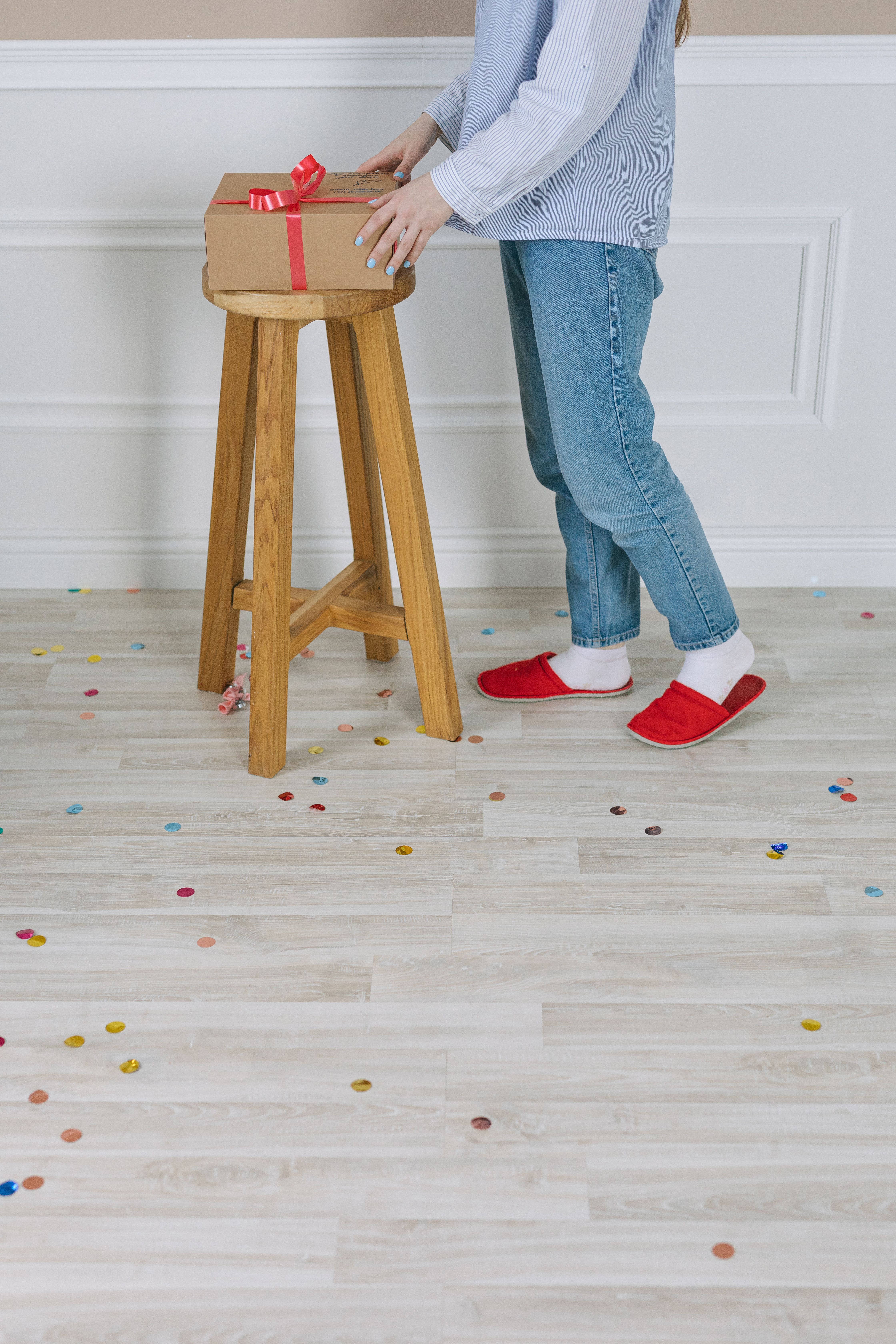 A Person Wearing Red Slippers Standing Beside a Wooden Stool · Free ...