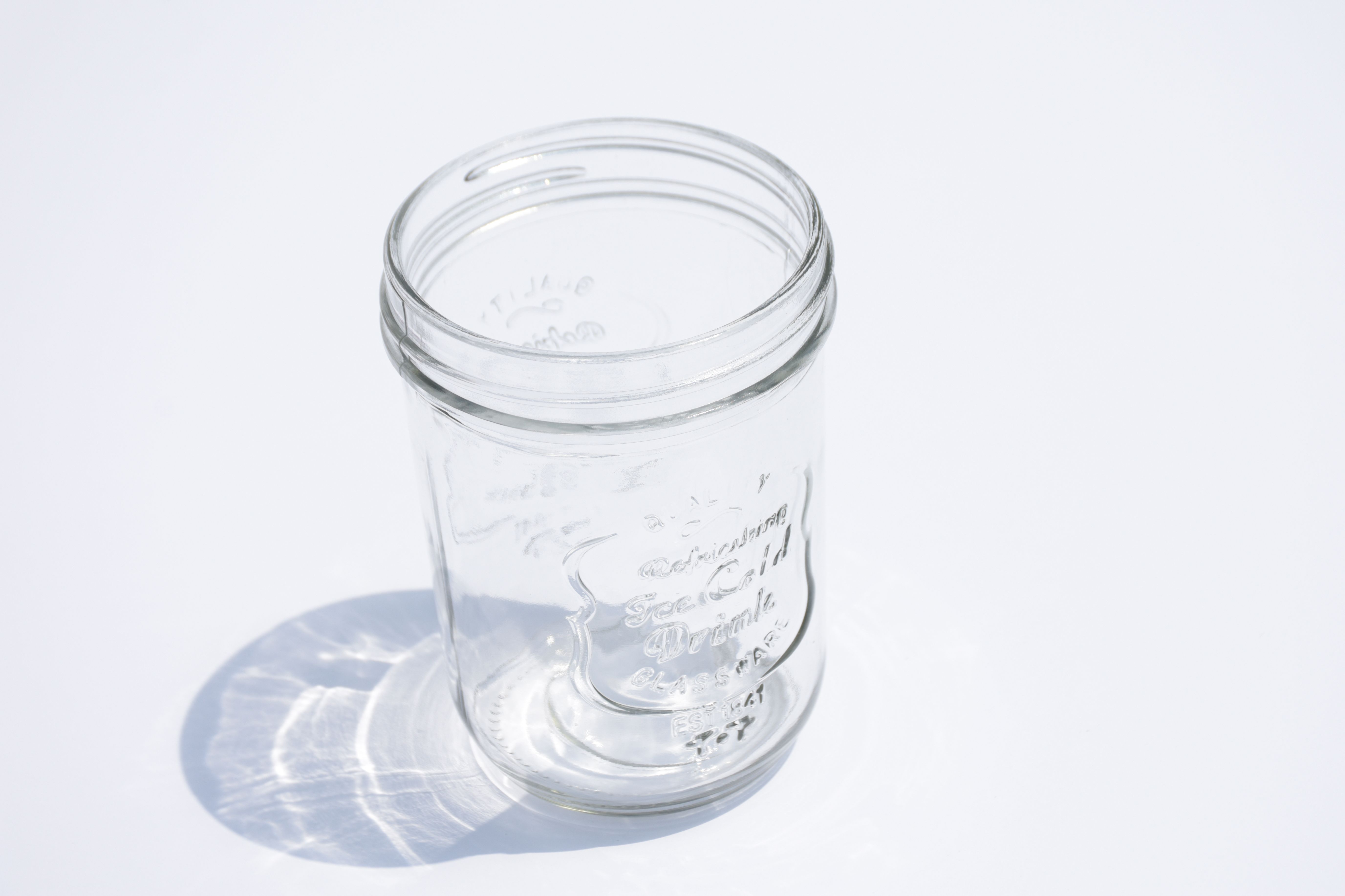 Close-Up Photo of an Empty Glass Jar on a White Surface · Free Stock Photo