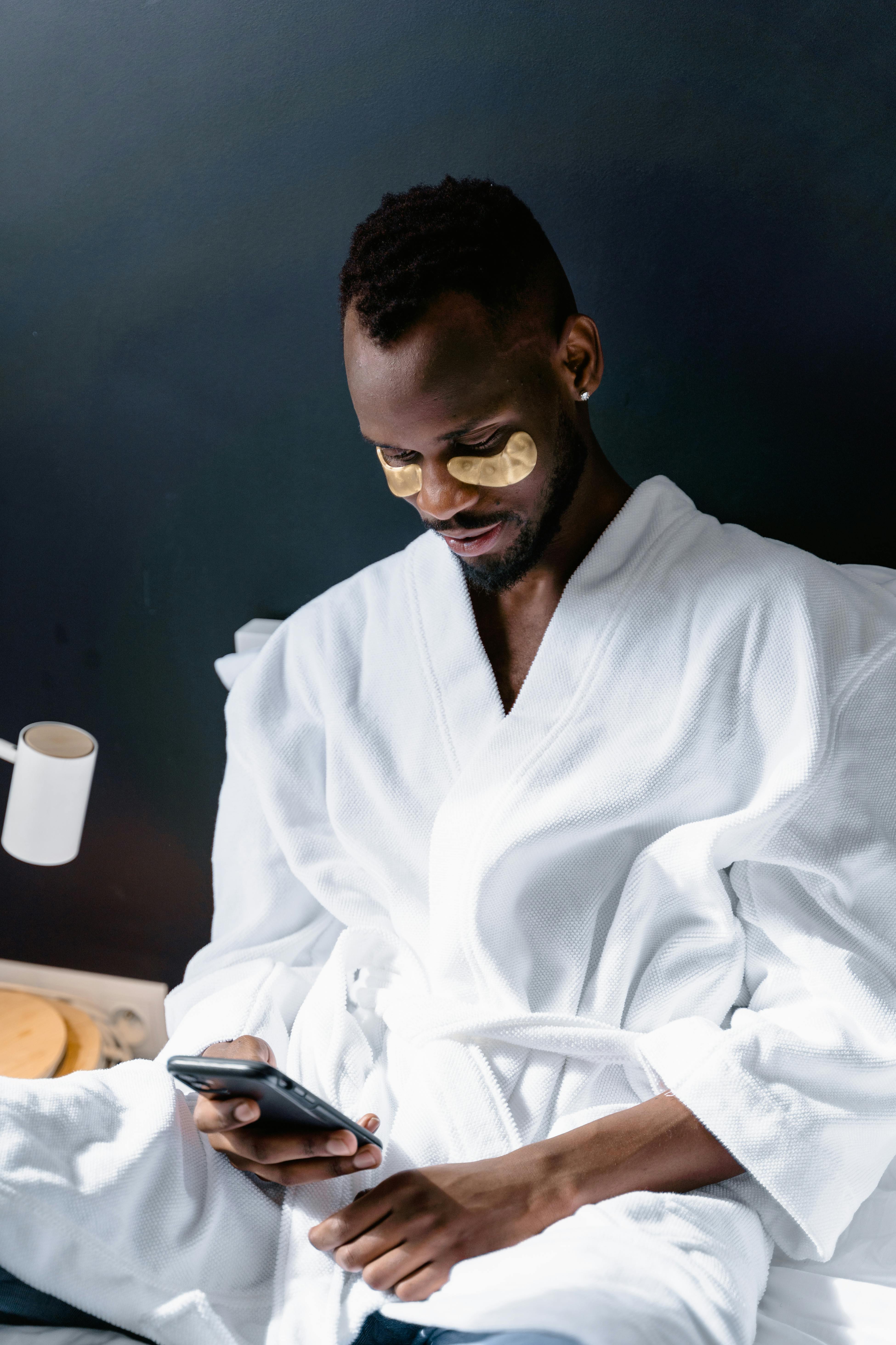 Man in White Robe Using an iPhone · Free Stock Photo