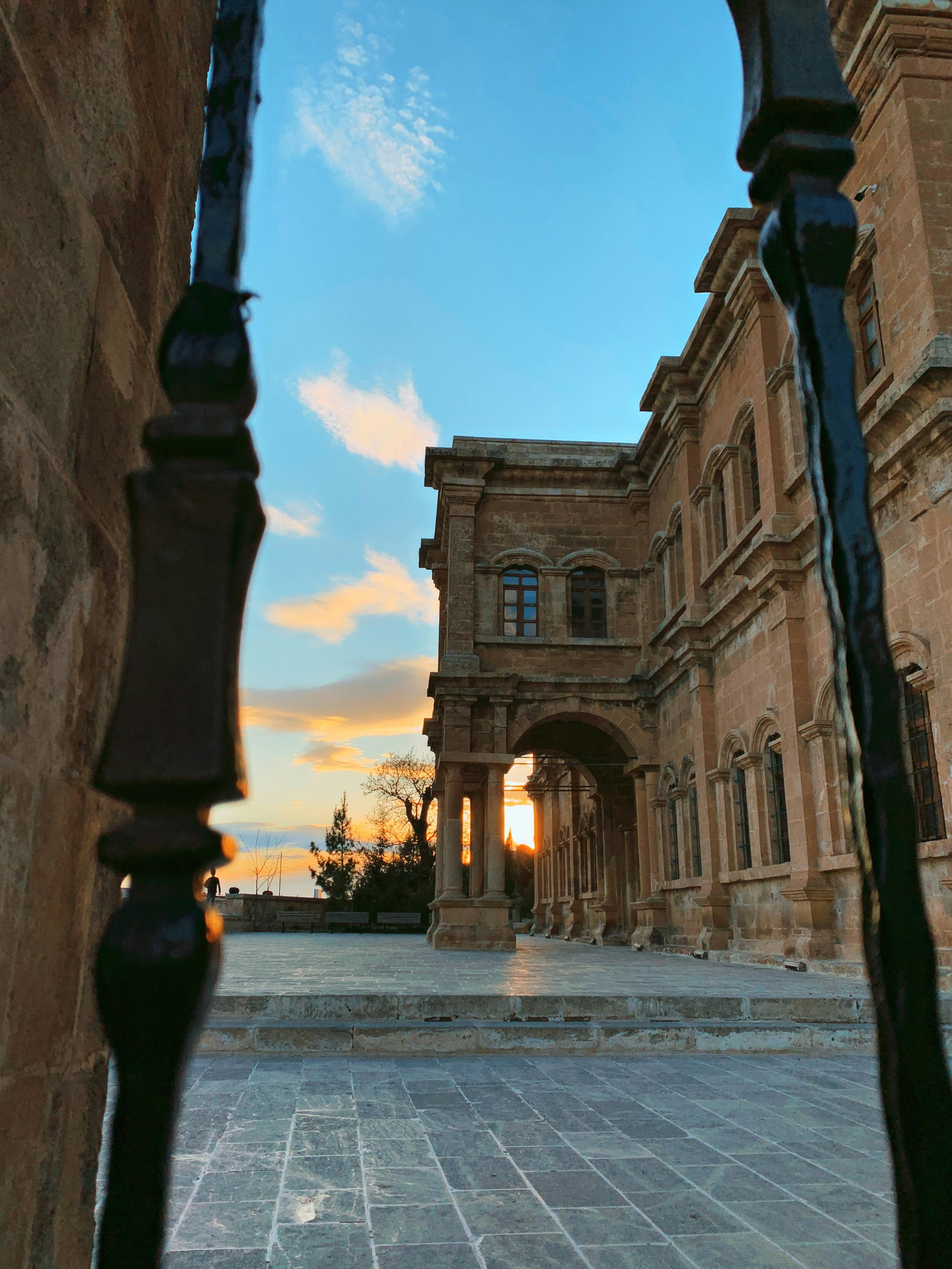 Brown Concrete Building Behind Metal Railings · Free Stock Photo
