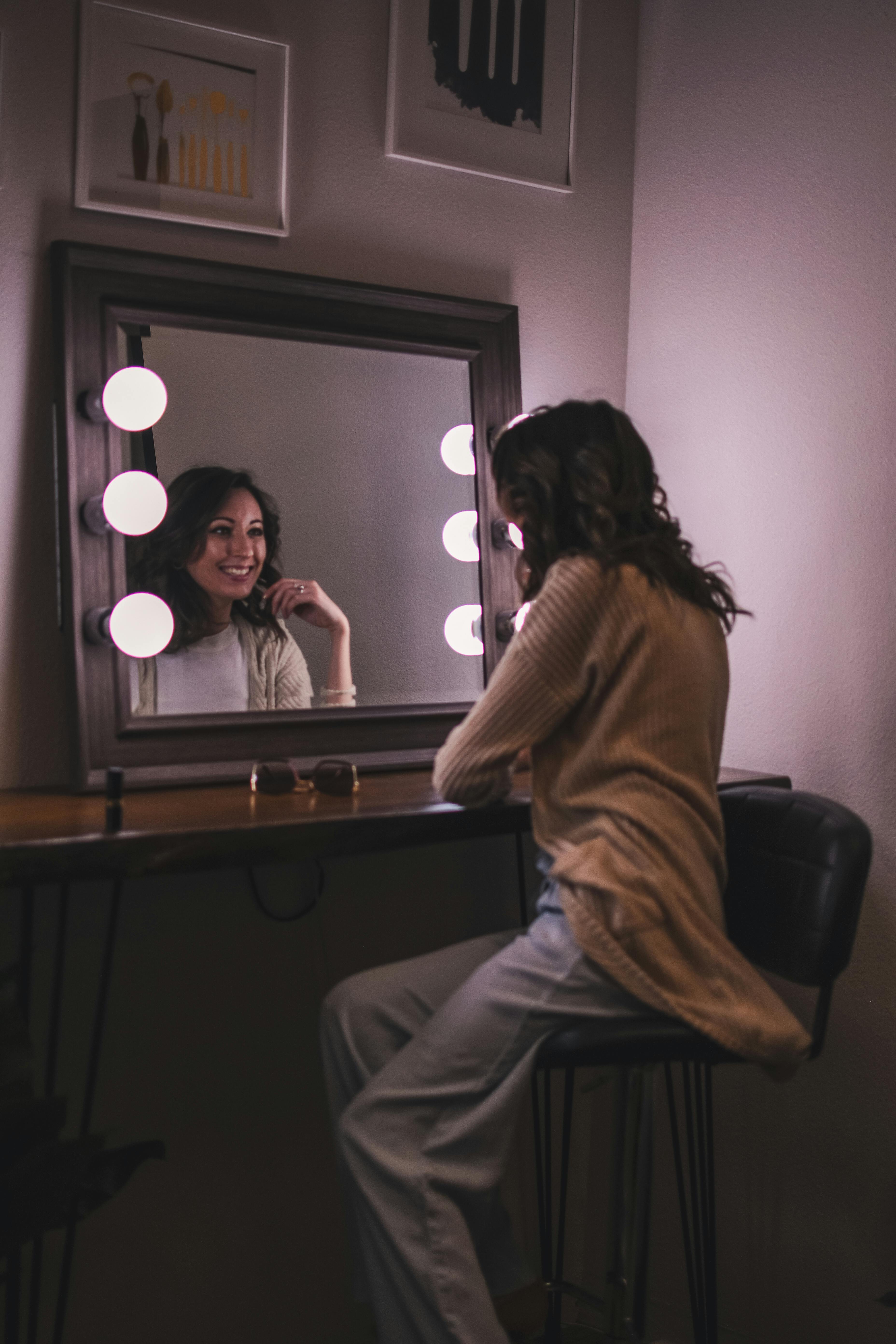 Cheerful woman looking in mirror in dressing room · Free Stock Photo