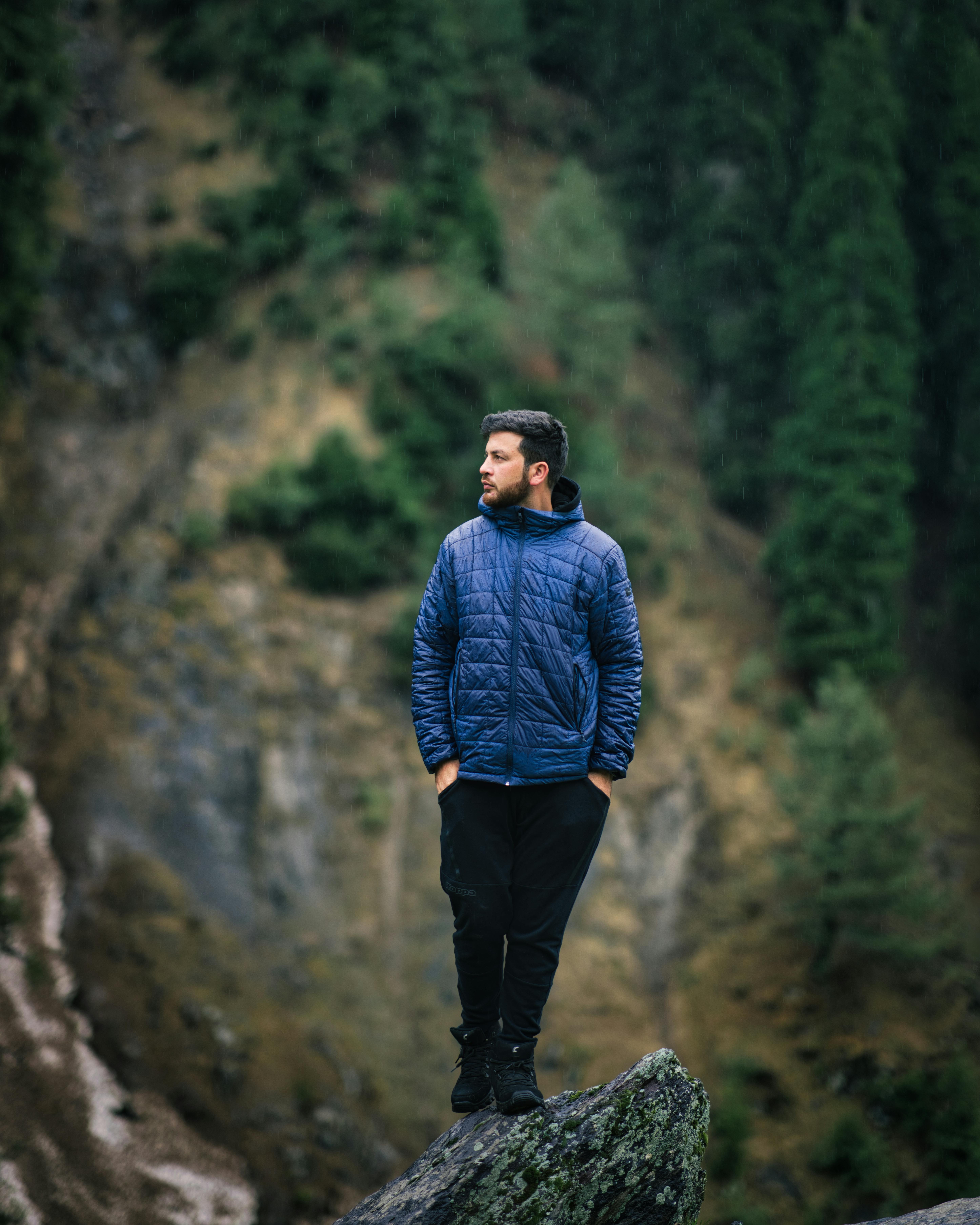 Man in Blue Jacket Standing on Rock · Free Stock Photo