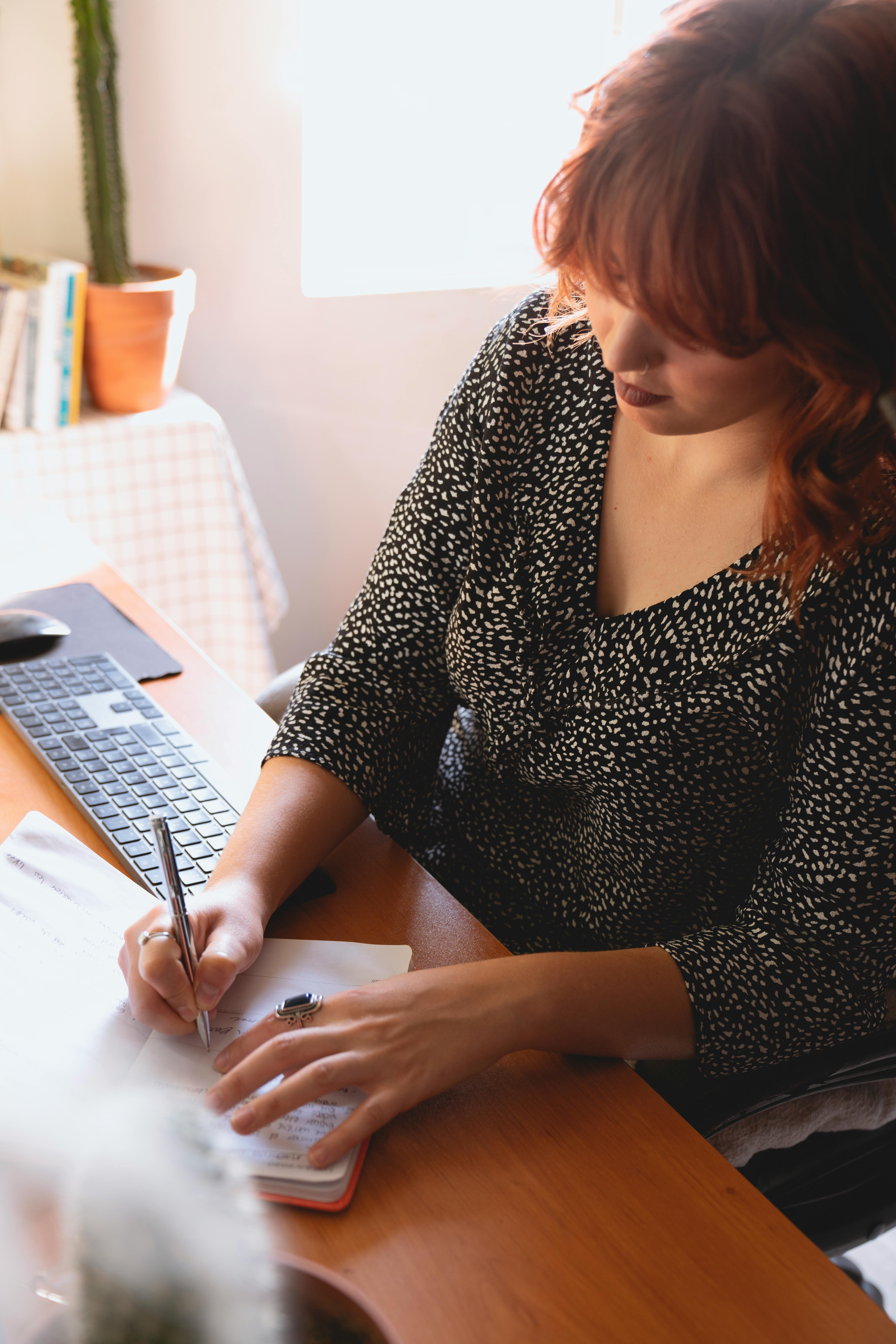 Woman Writing on Her Notebook · Free Stock Photo