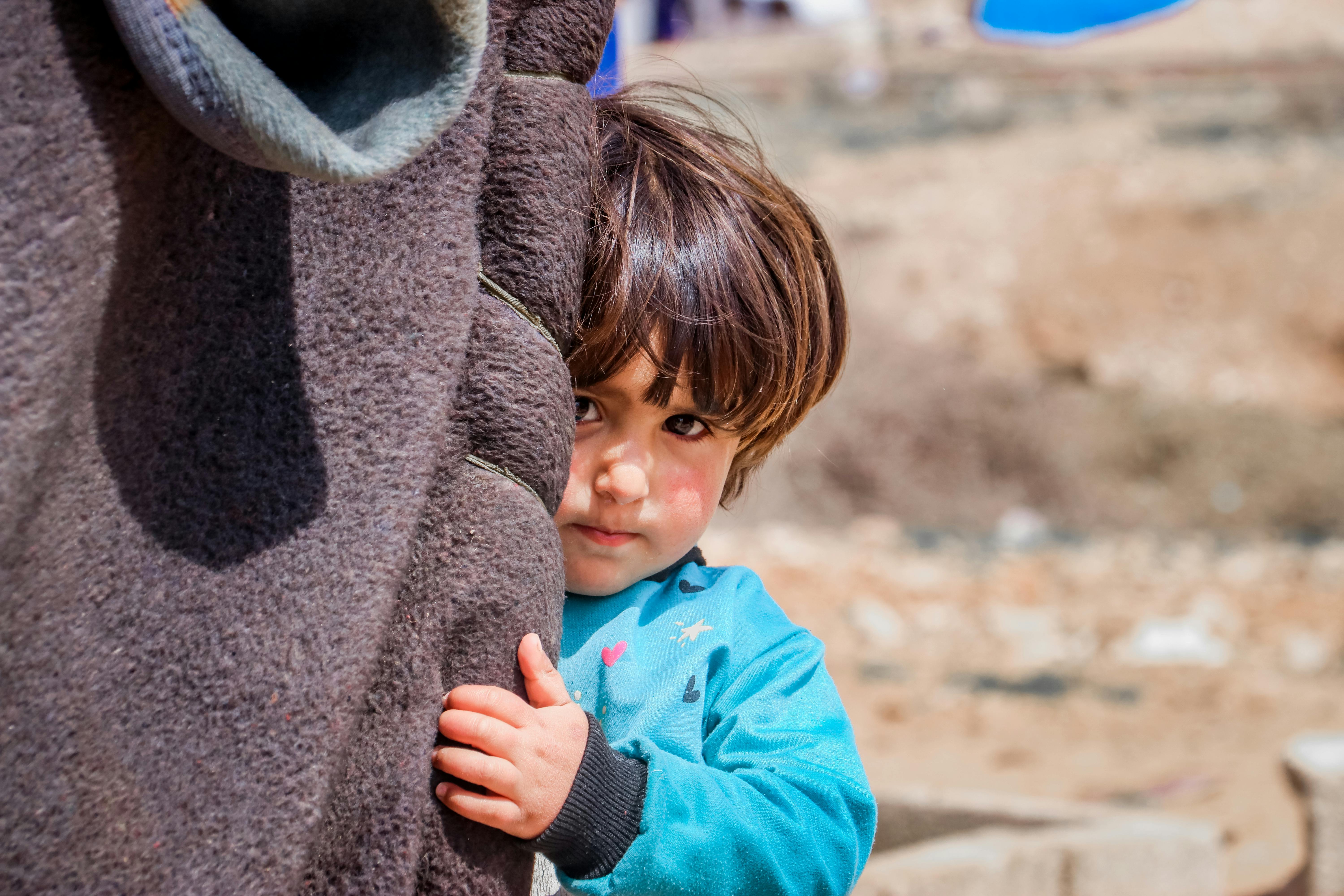 Anonymous black little kid hiding in wardrobe · Free Stock Photo