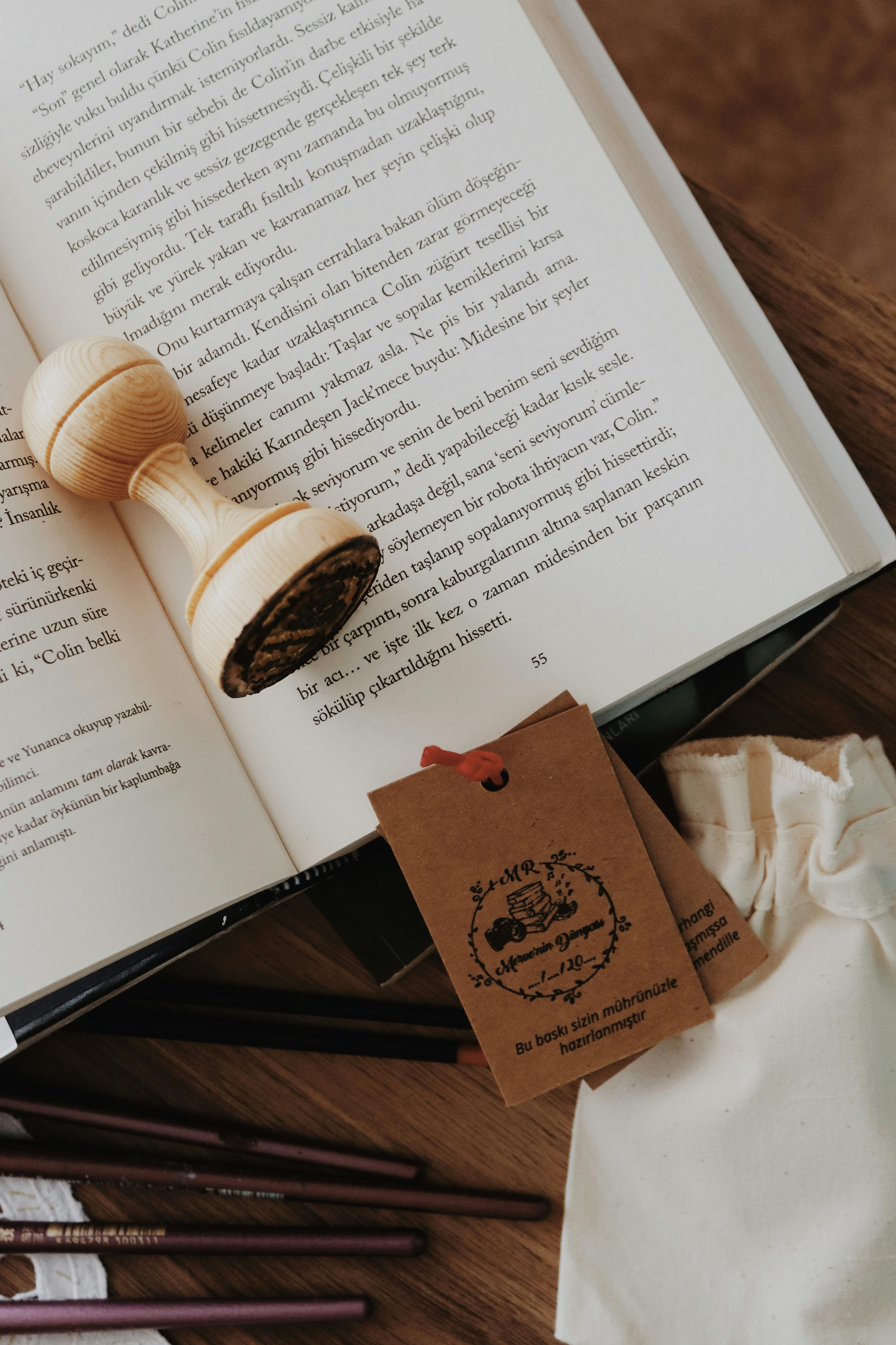 Book and Stamp on Wooden Table · Free Stock Photo