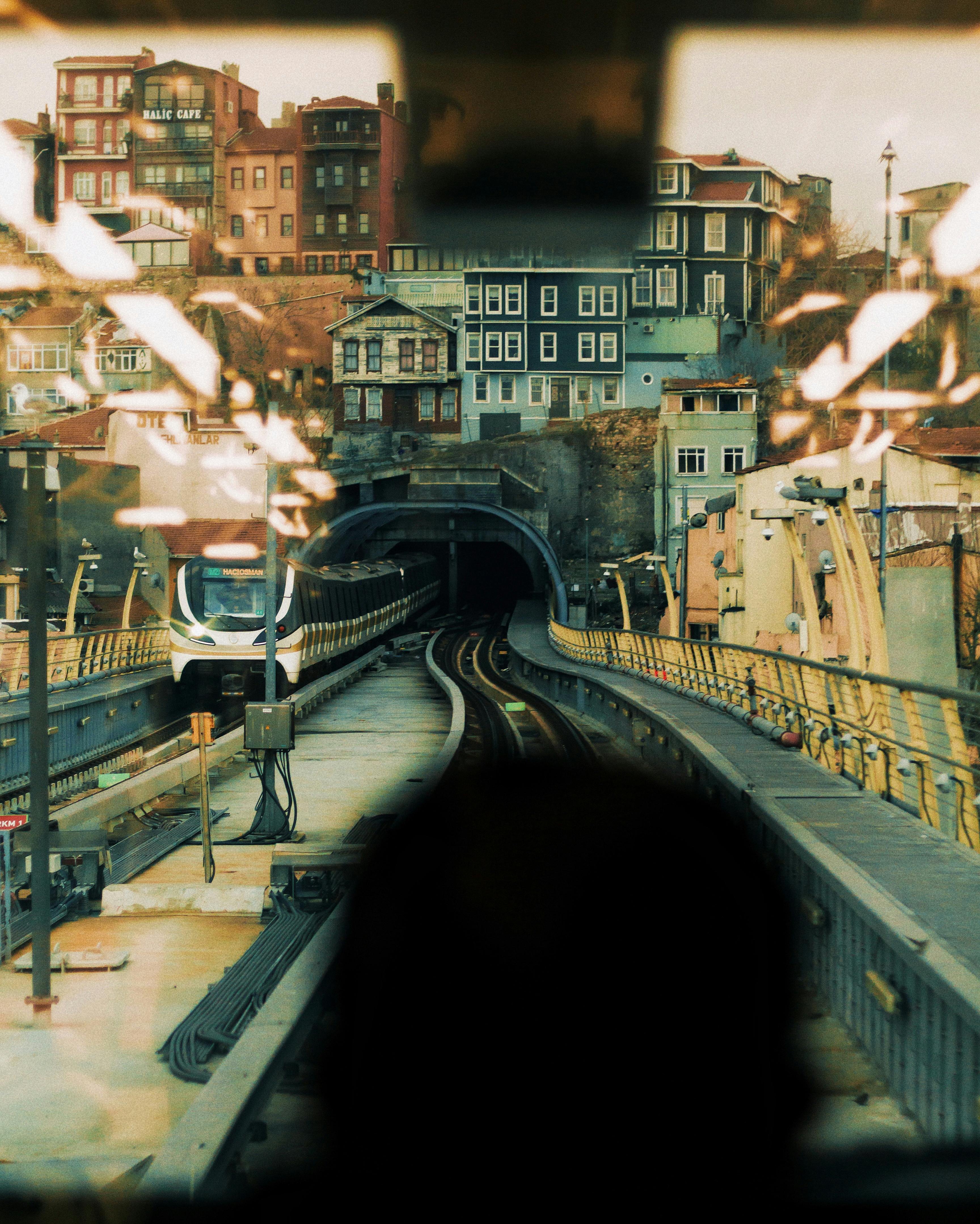 From train window view of railroad and buildings in city · Free Stock Photo