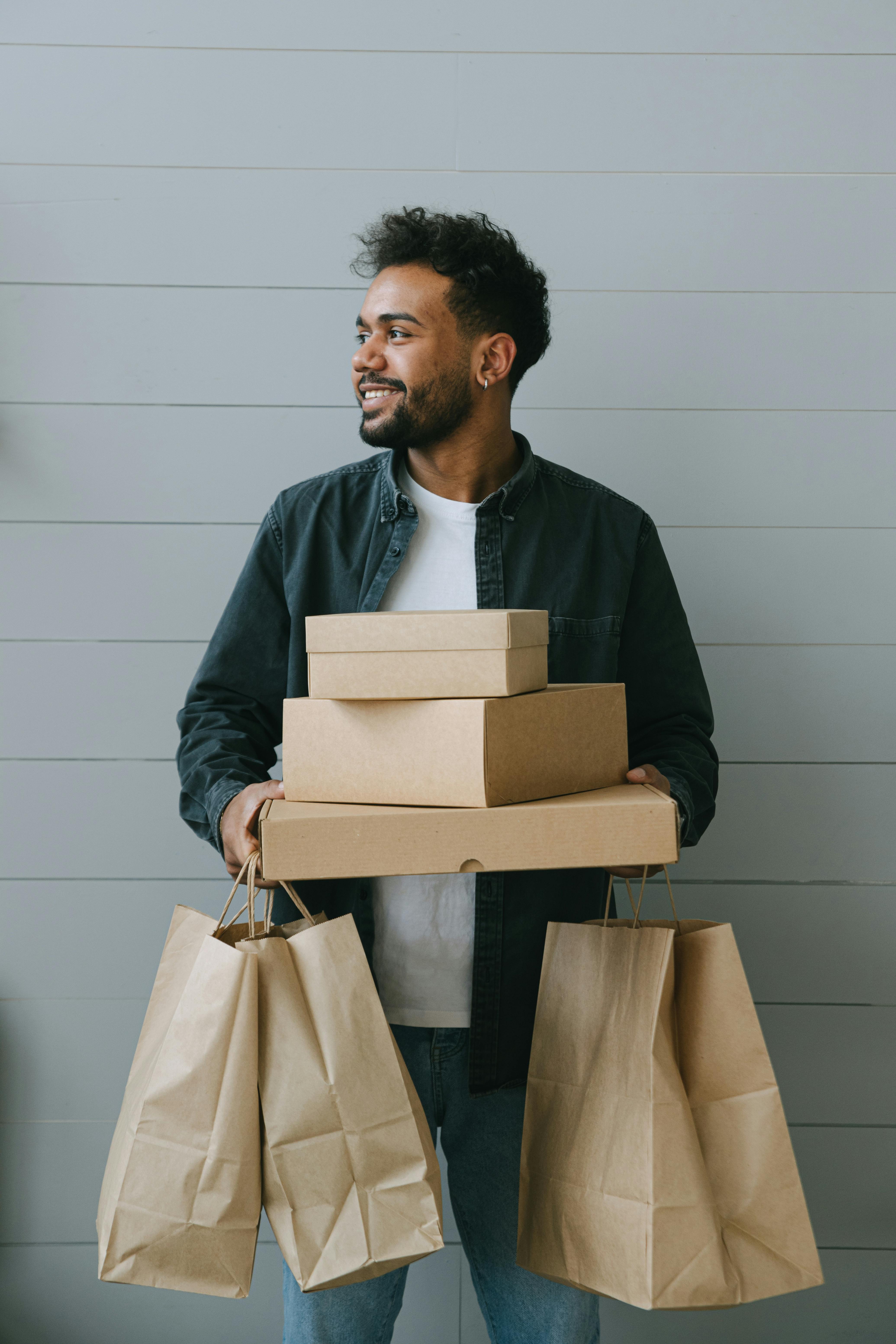 A Man Holding Boxes and Paper Bags · Free Stock Photo