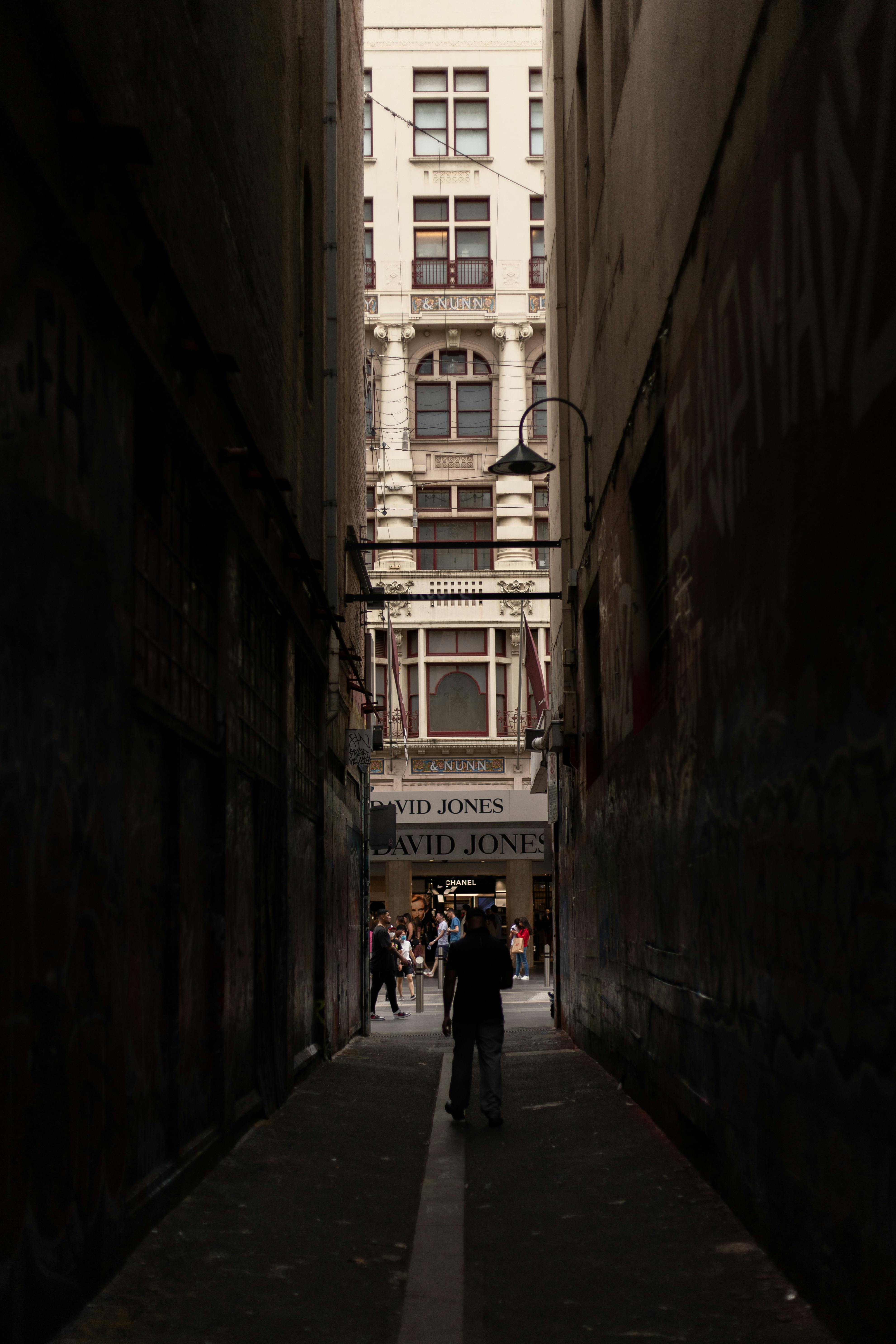 Person Walking Between Buildings · Free Stock Photo