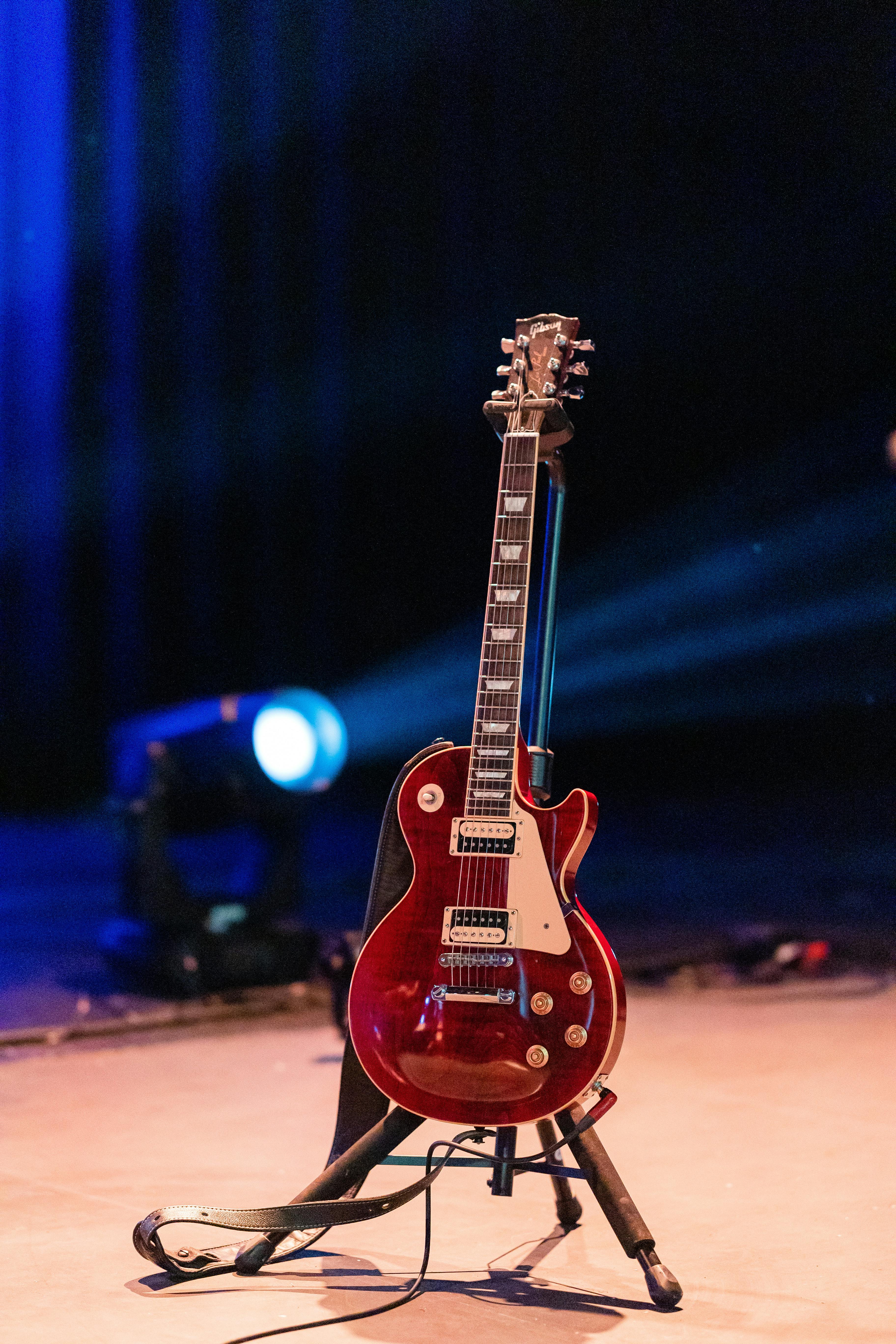 Modern electric guitar on stage against spotlight · Free Stock Photo
