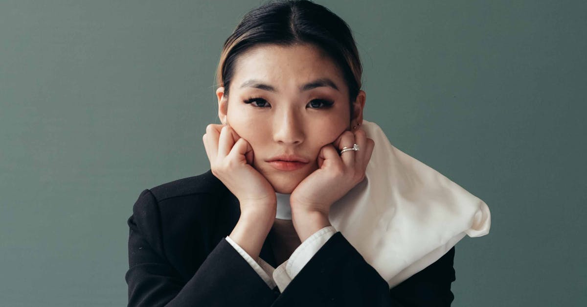 꽃이 있는 테이블에 손을 기대고 있는 아시아 여성 · 무료 스톡 사진
