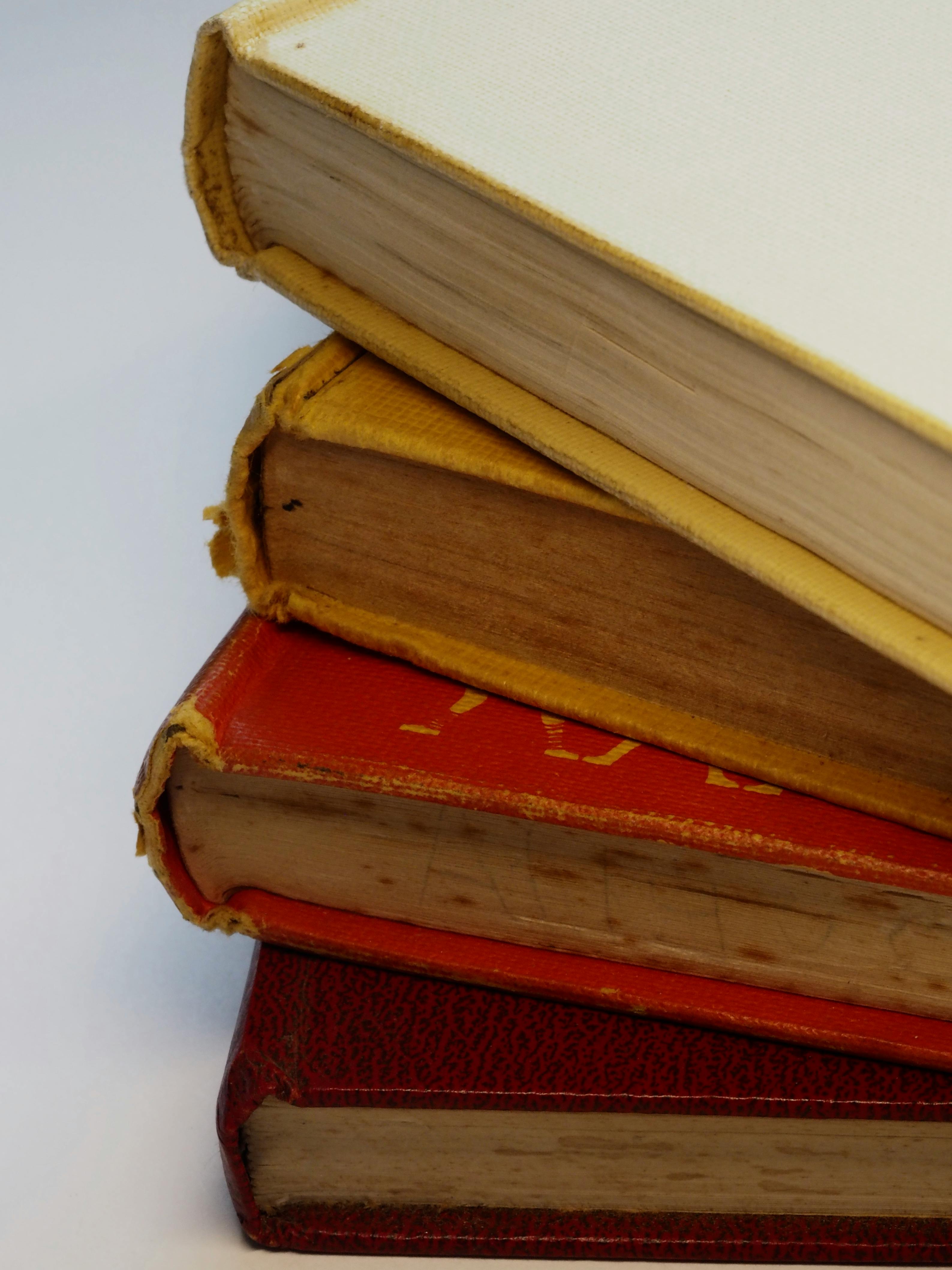 Four Assorted-color Hardbound Books · Free Stock Photo