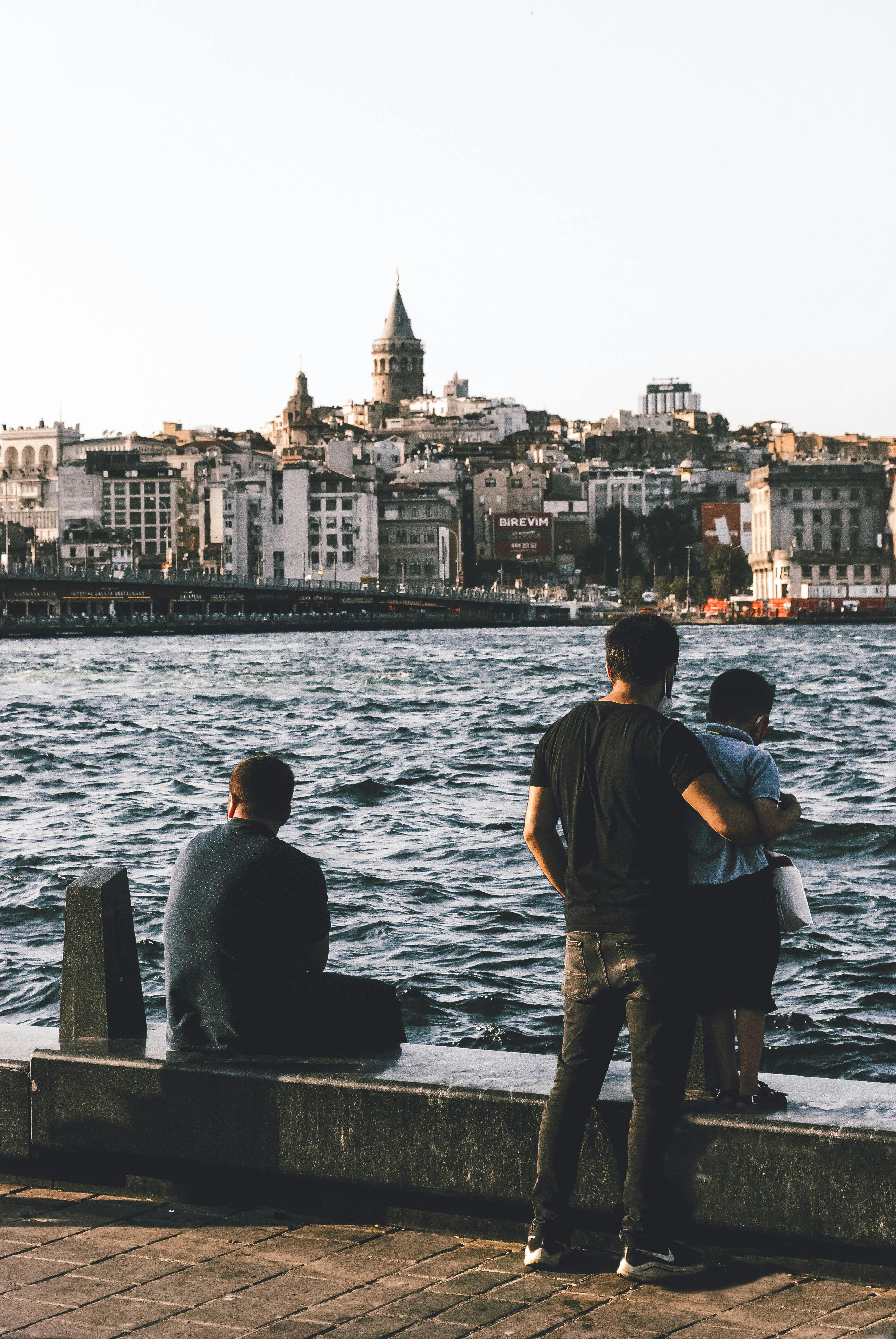 Back View of People Enjoying the Seawall · Free Stock Photo