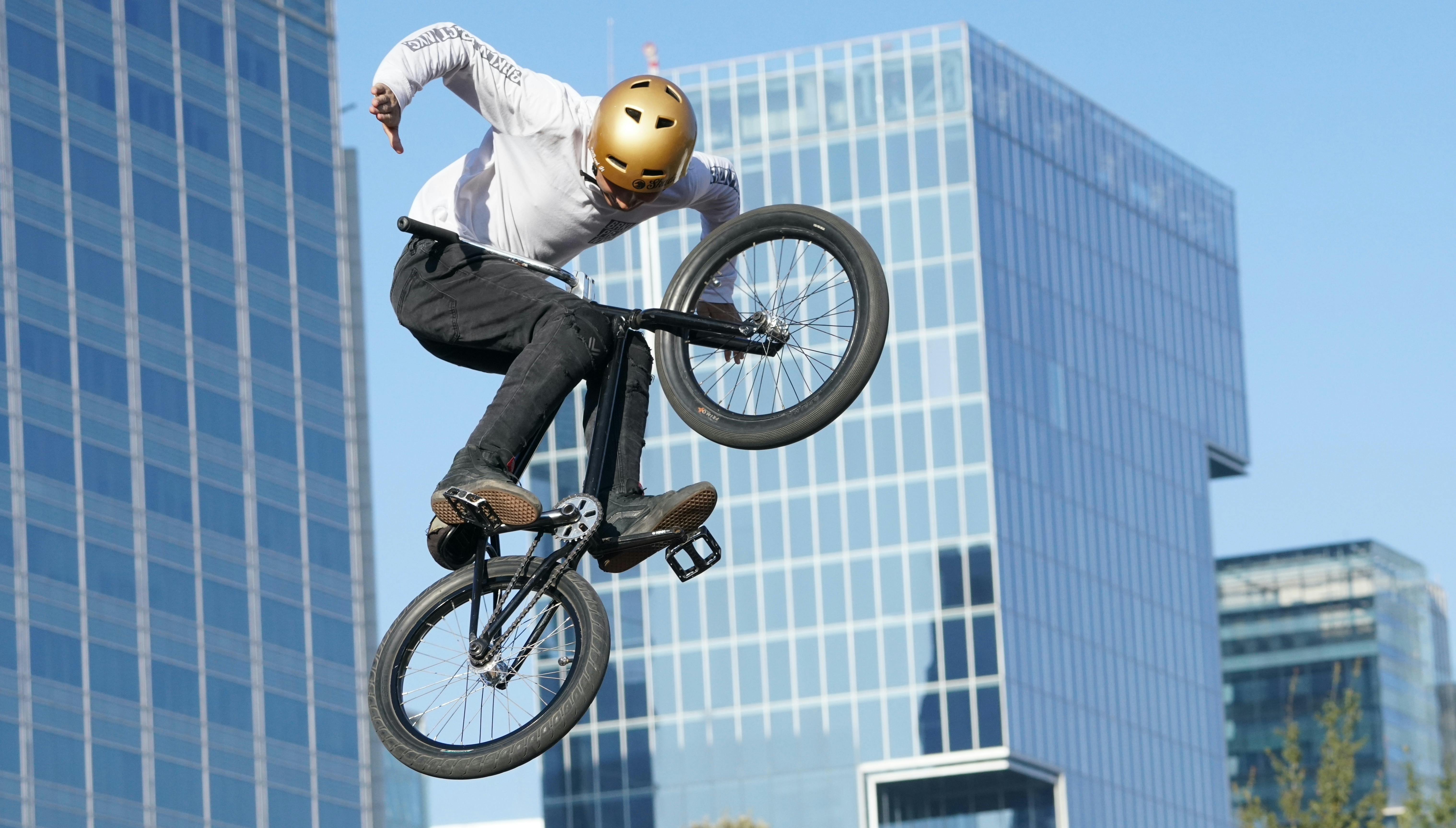 A Man Riding on a Bicycle while Doing Tricks in the Air · Free Stock Photo