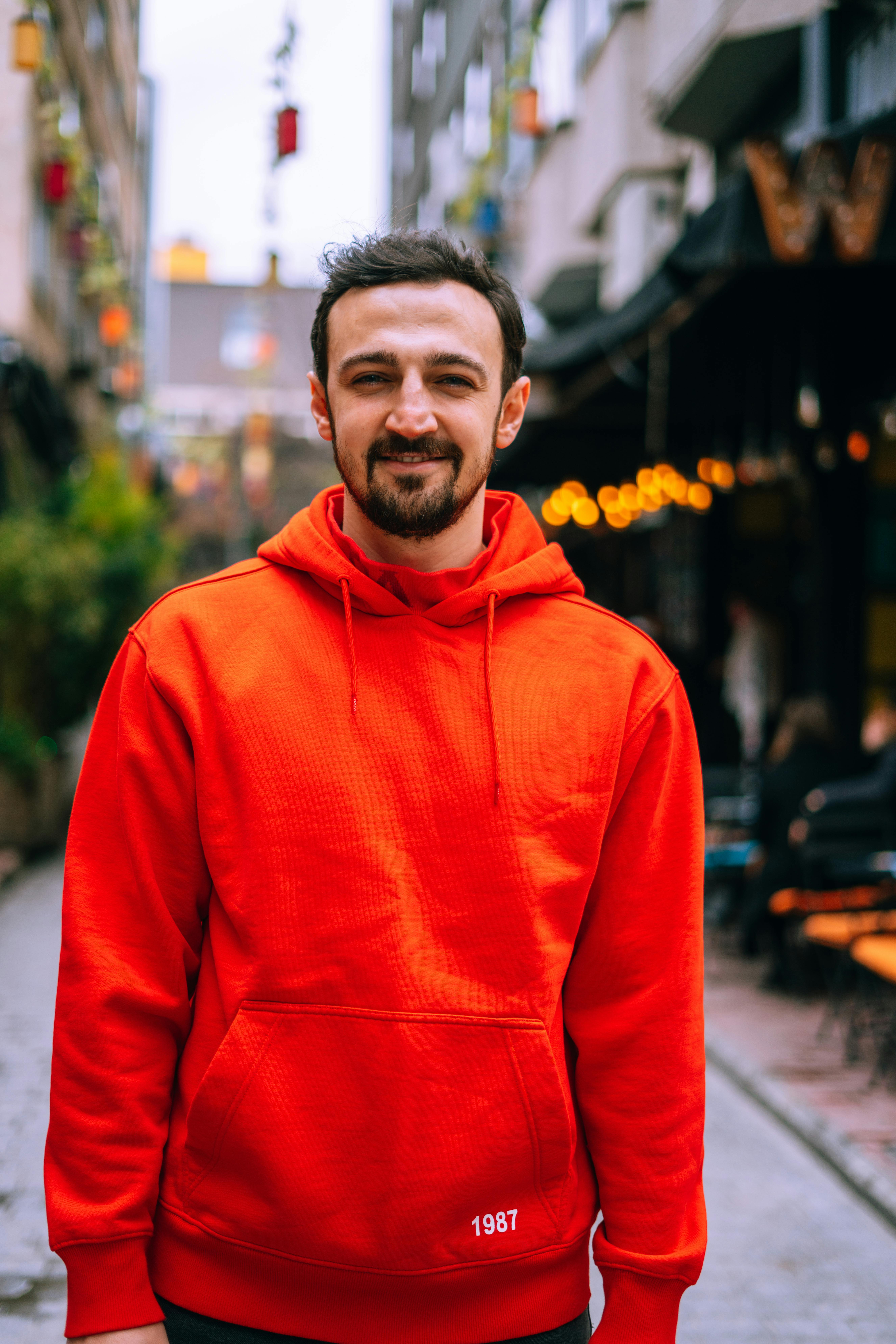Man in Red Hoodie Standing Near Building · Free Stock Photo