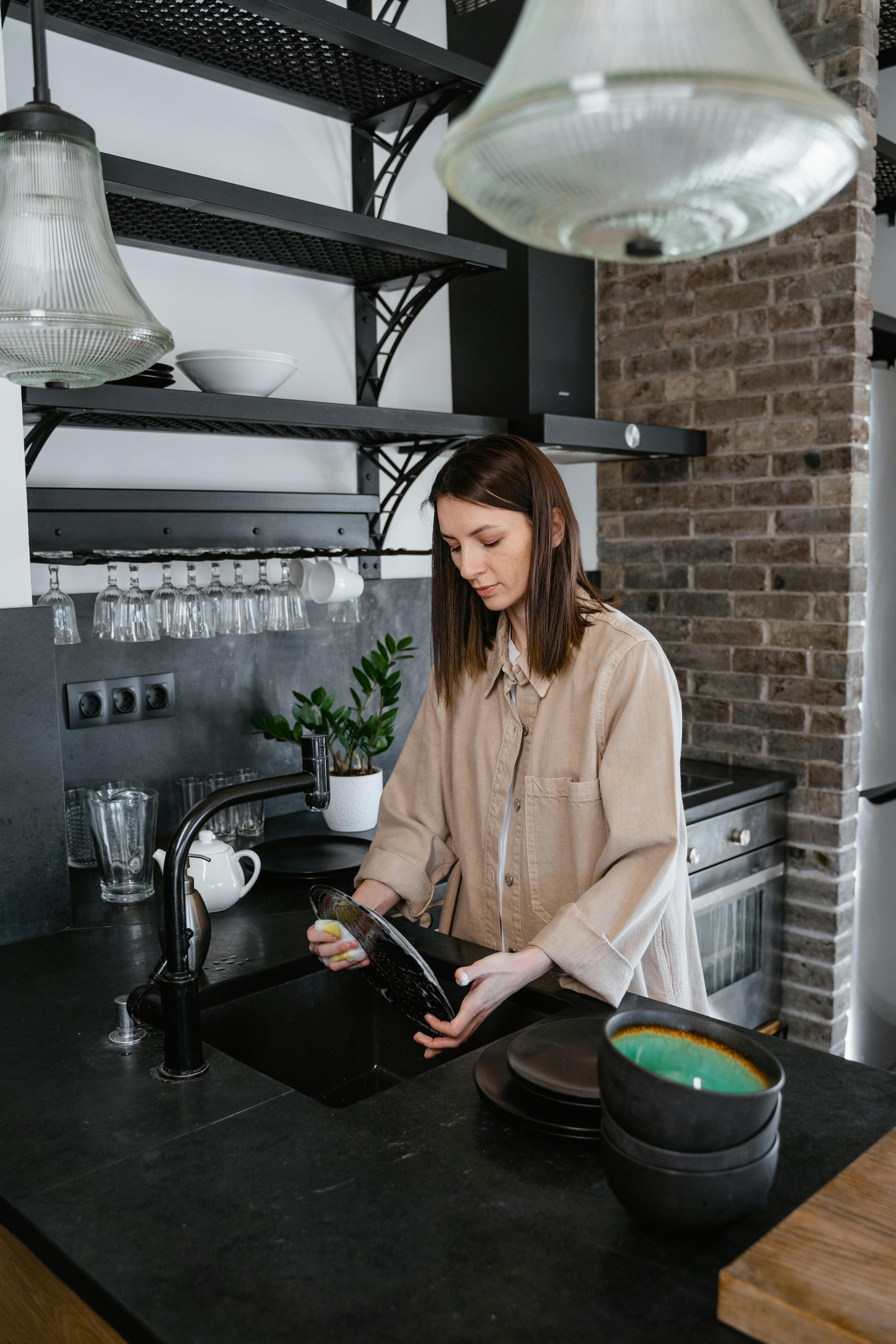 A Woman Washing the Dishes in the Kitchen · Free Stock Photo