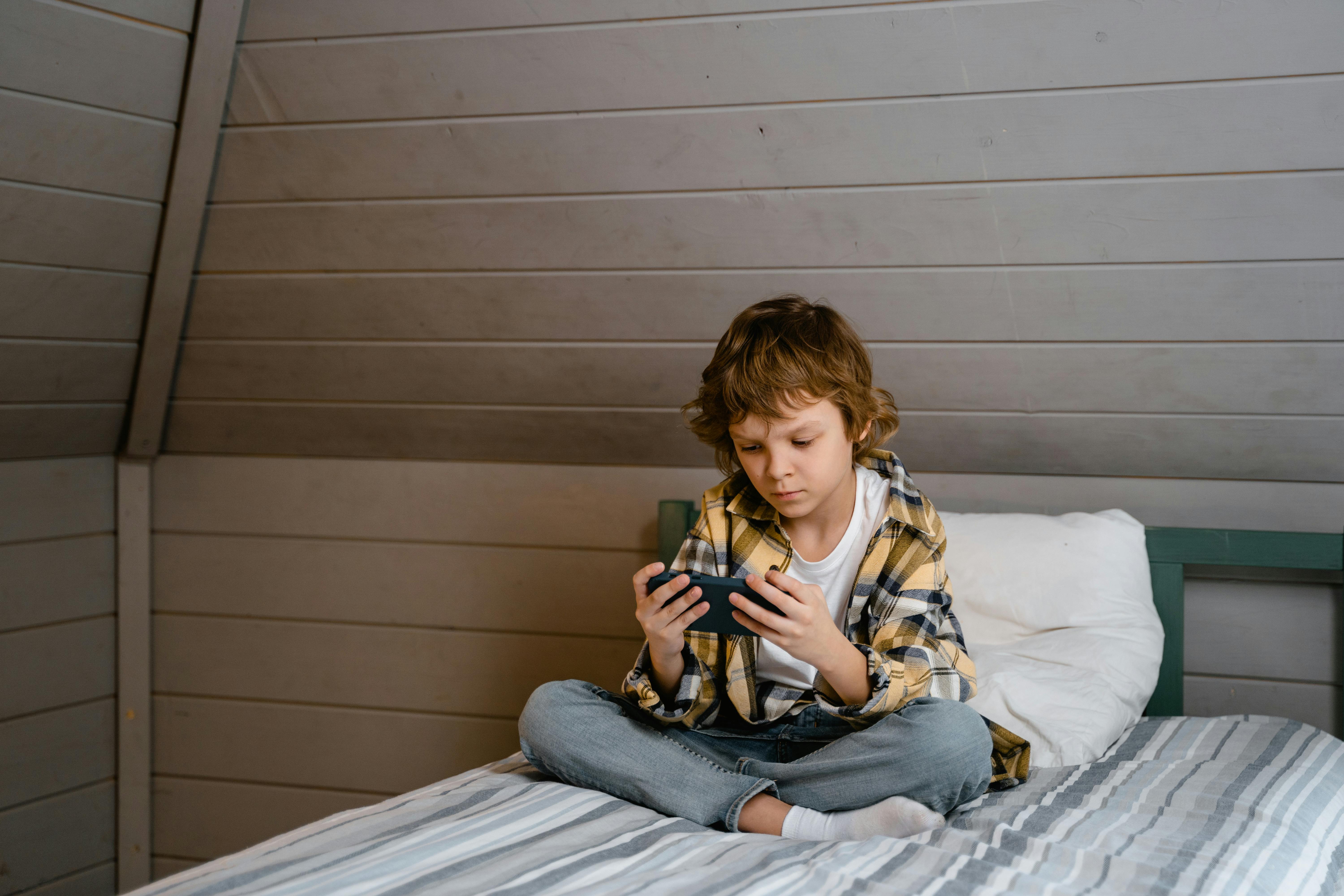 A Boy Using a Mobile Phone · Free Stock Photo