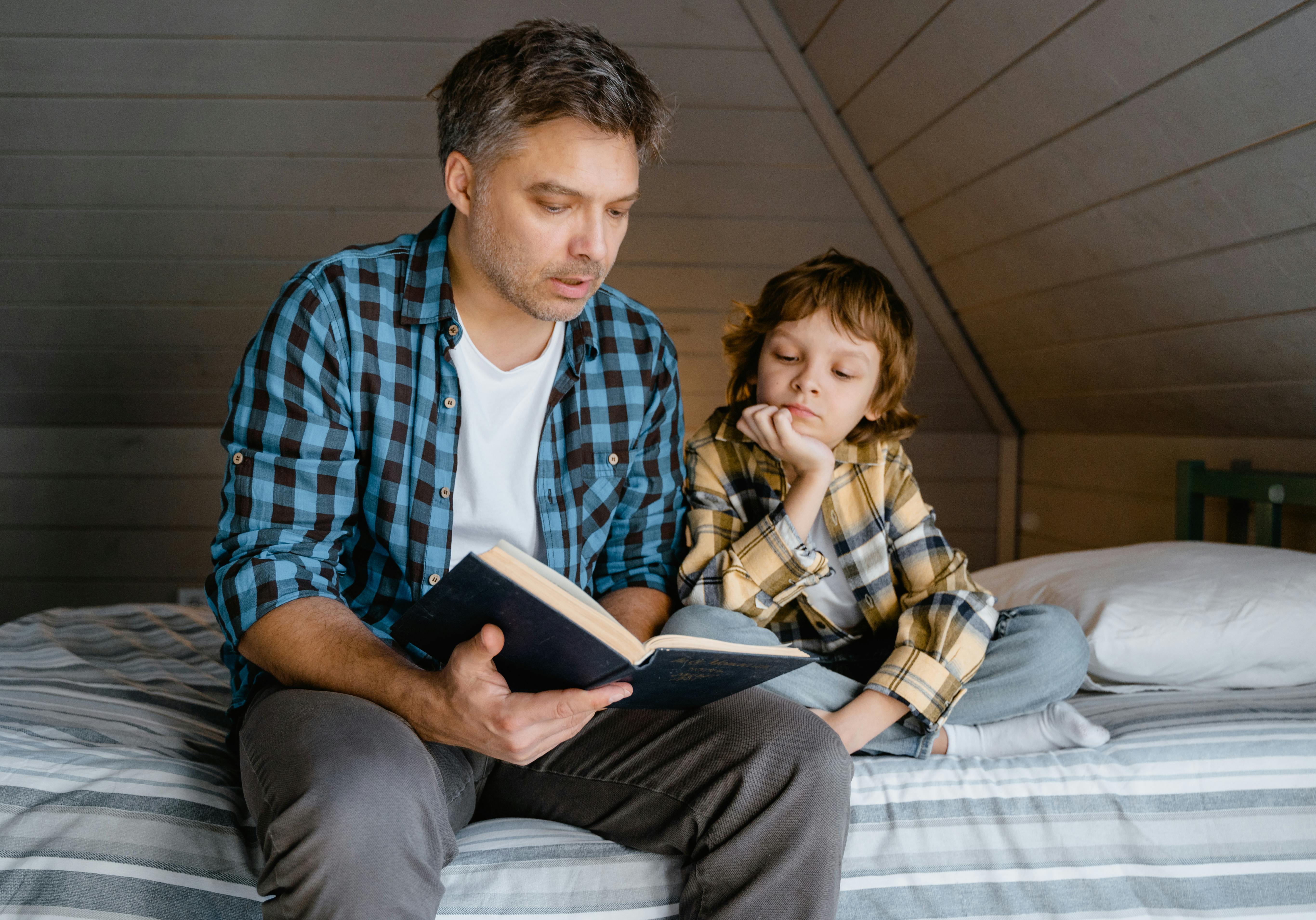 A Man Reading a Book to His Son · Free Stock Photo