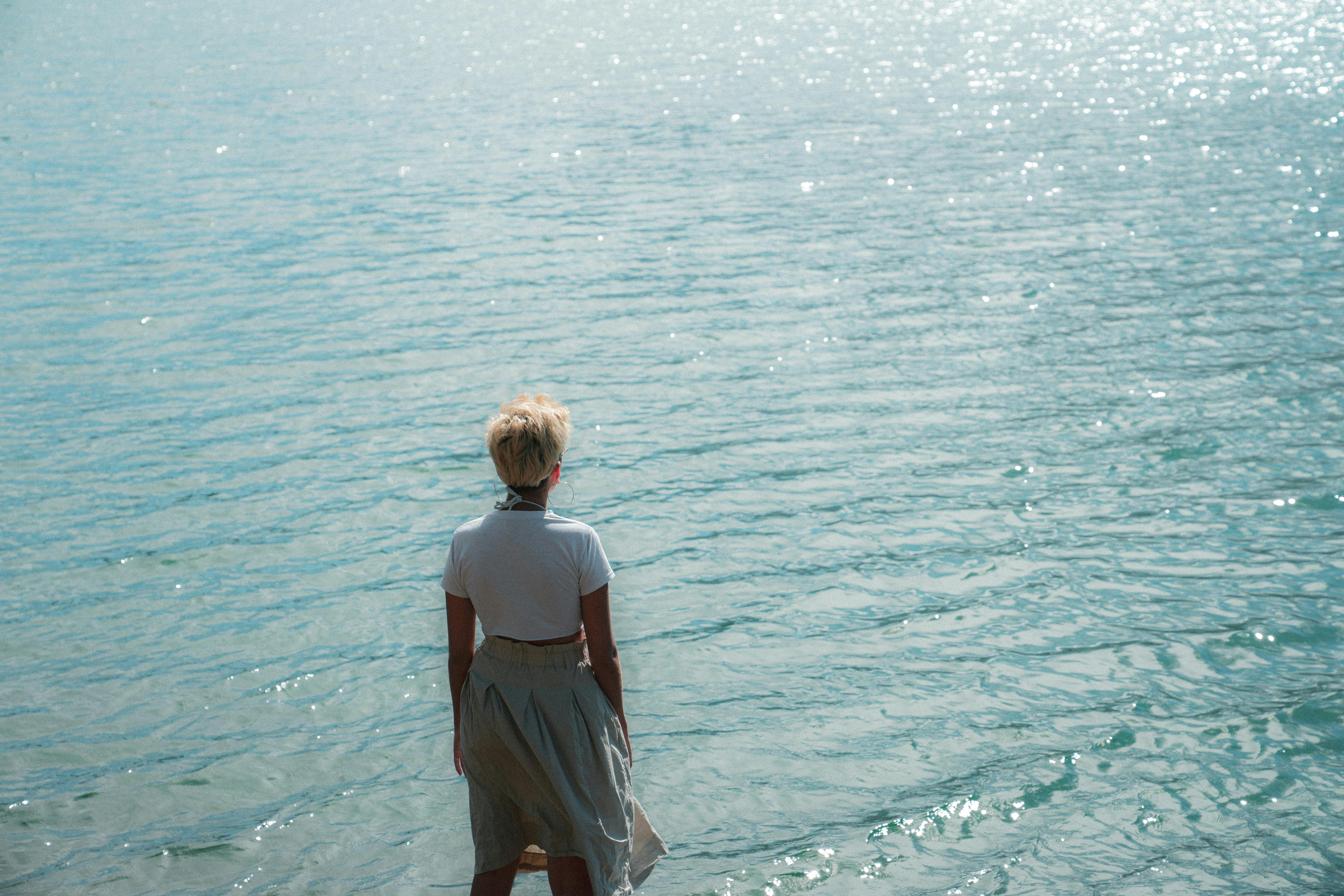 Back View of a Person Standing by a Lake · Free Stock Photo