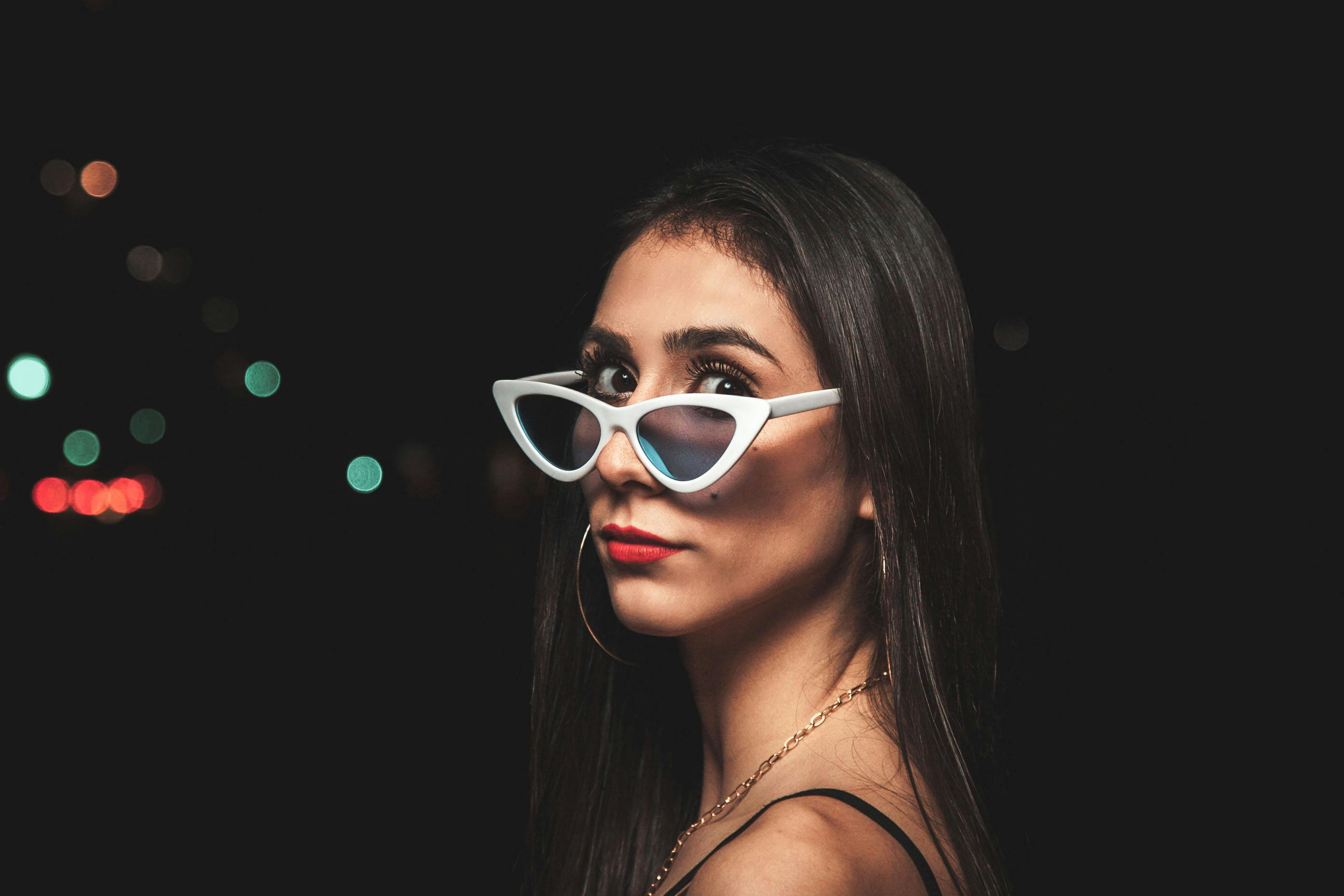Young Woman Looking Over Sunglasses on Face · Free Stock Photo
