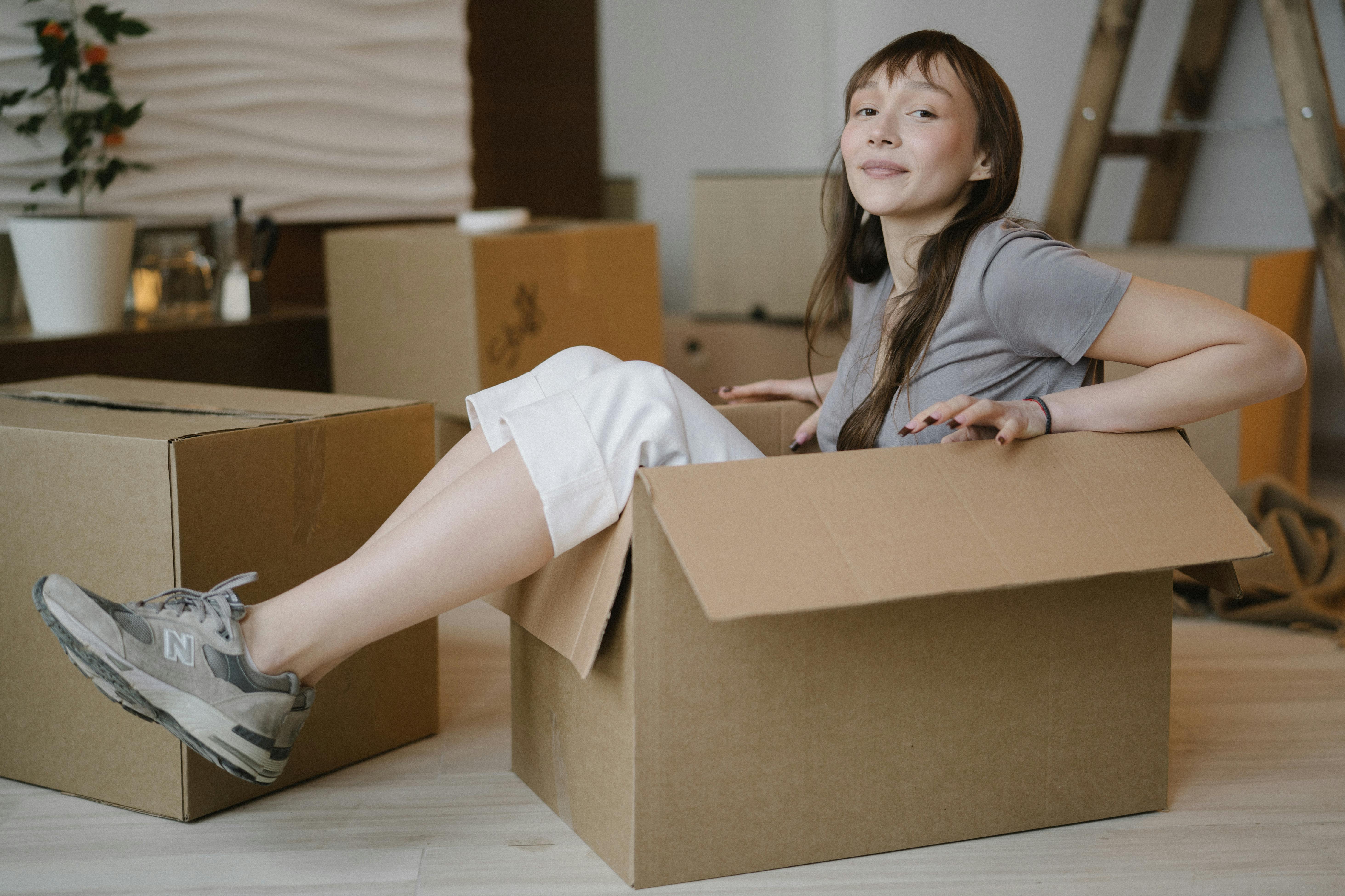 Photo of a Woman in a Cardboard Box · Free Stock Photo