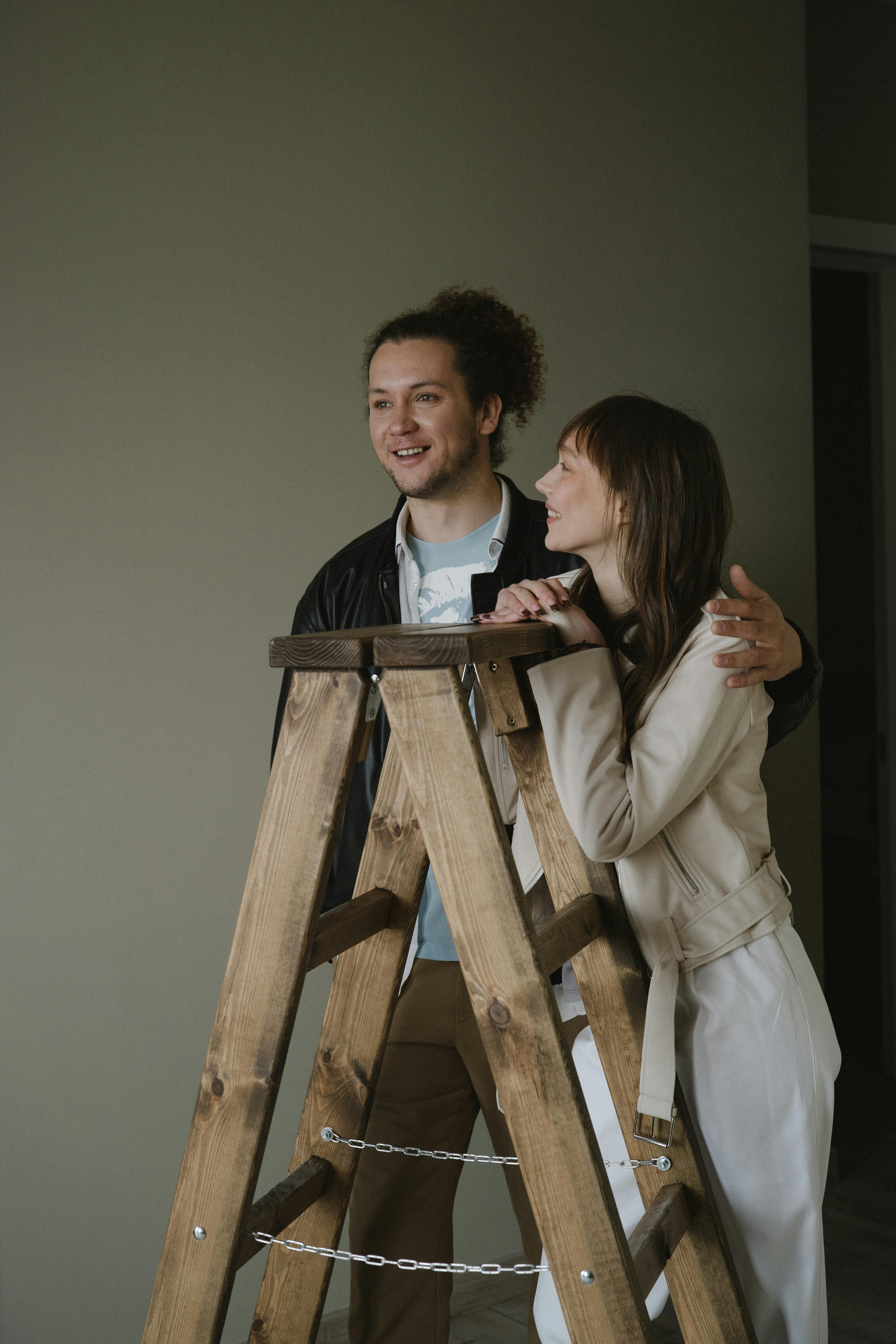 A Couple Standing Together Beside a Wooden Ladder · Free Stock Photo