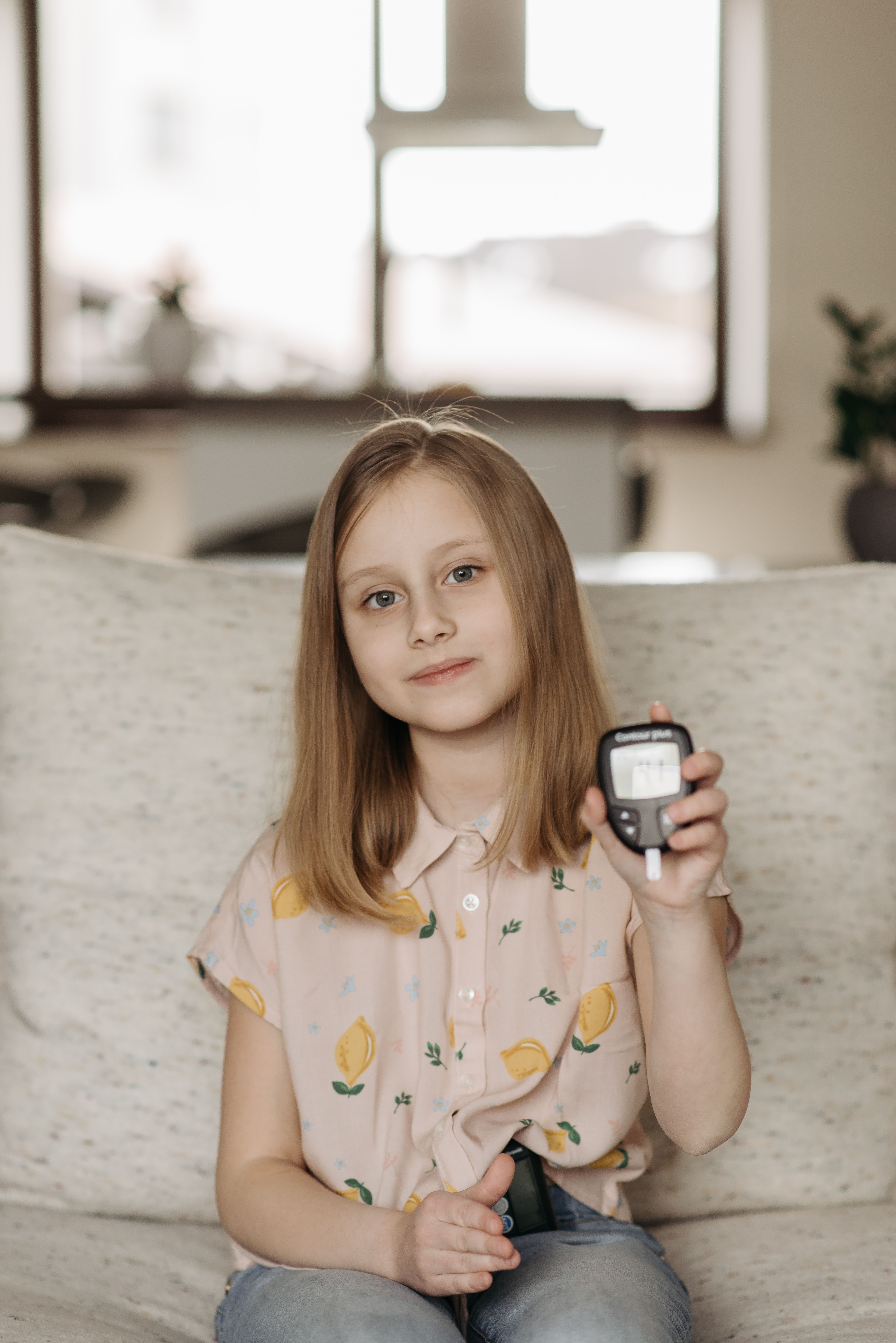 A Girl Holding a Glucometer · Free Stock Photo