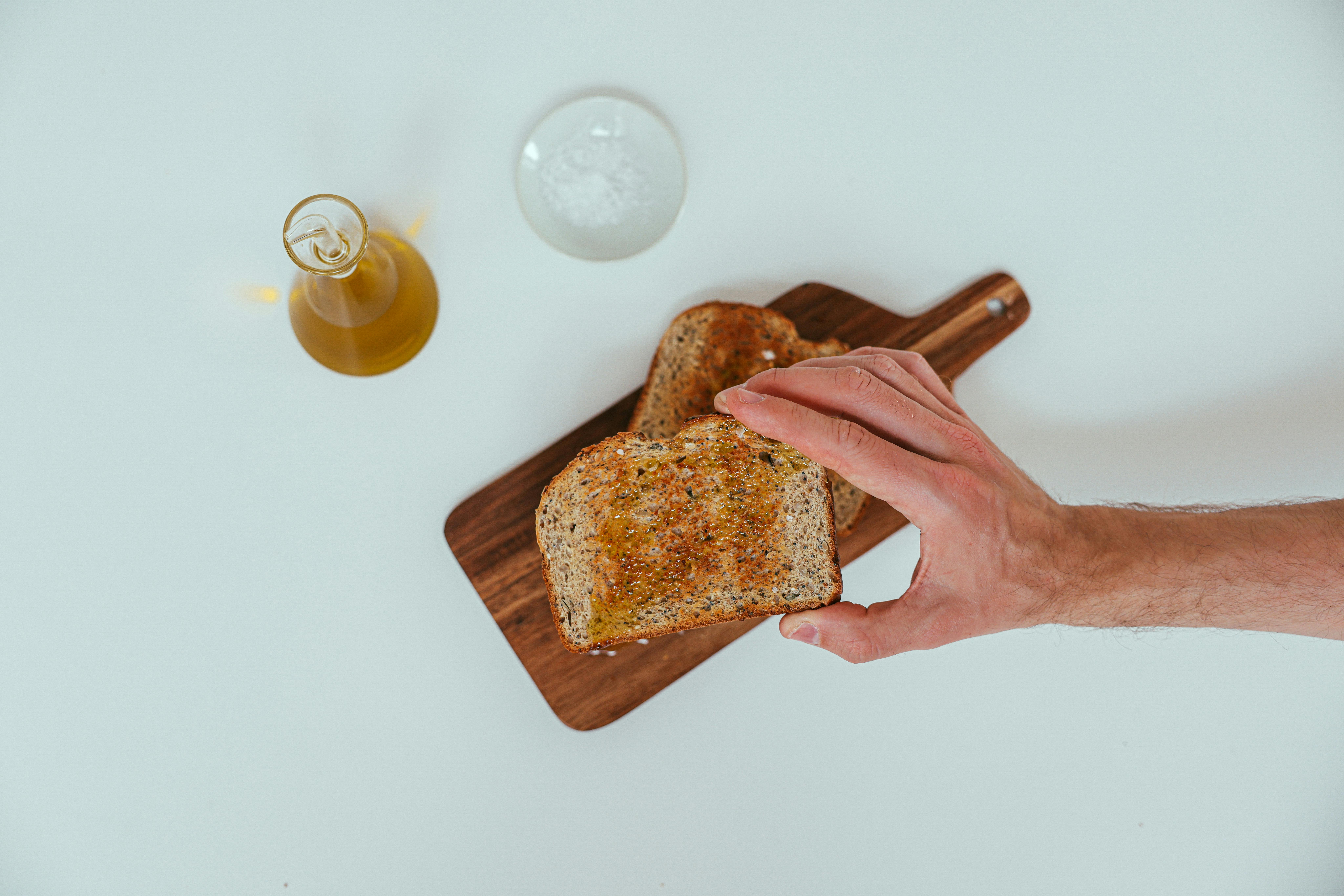 A Person Grabbing a Toasted Bread · Free Stock Photo