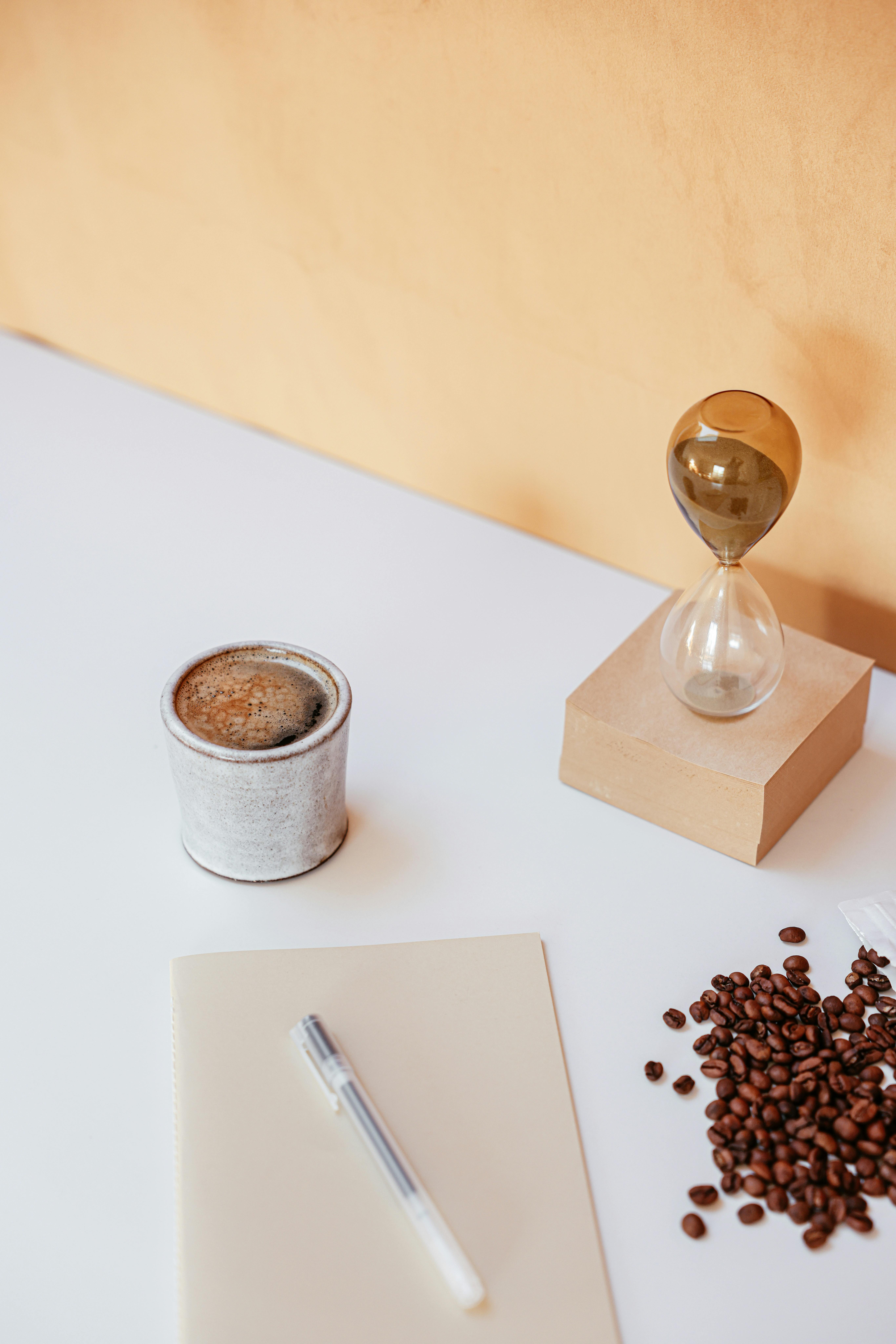 Clear Hour Glass beside Brown Leaves · Free Stock Photo