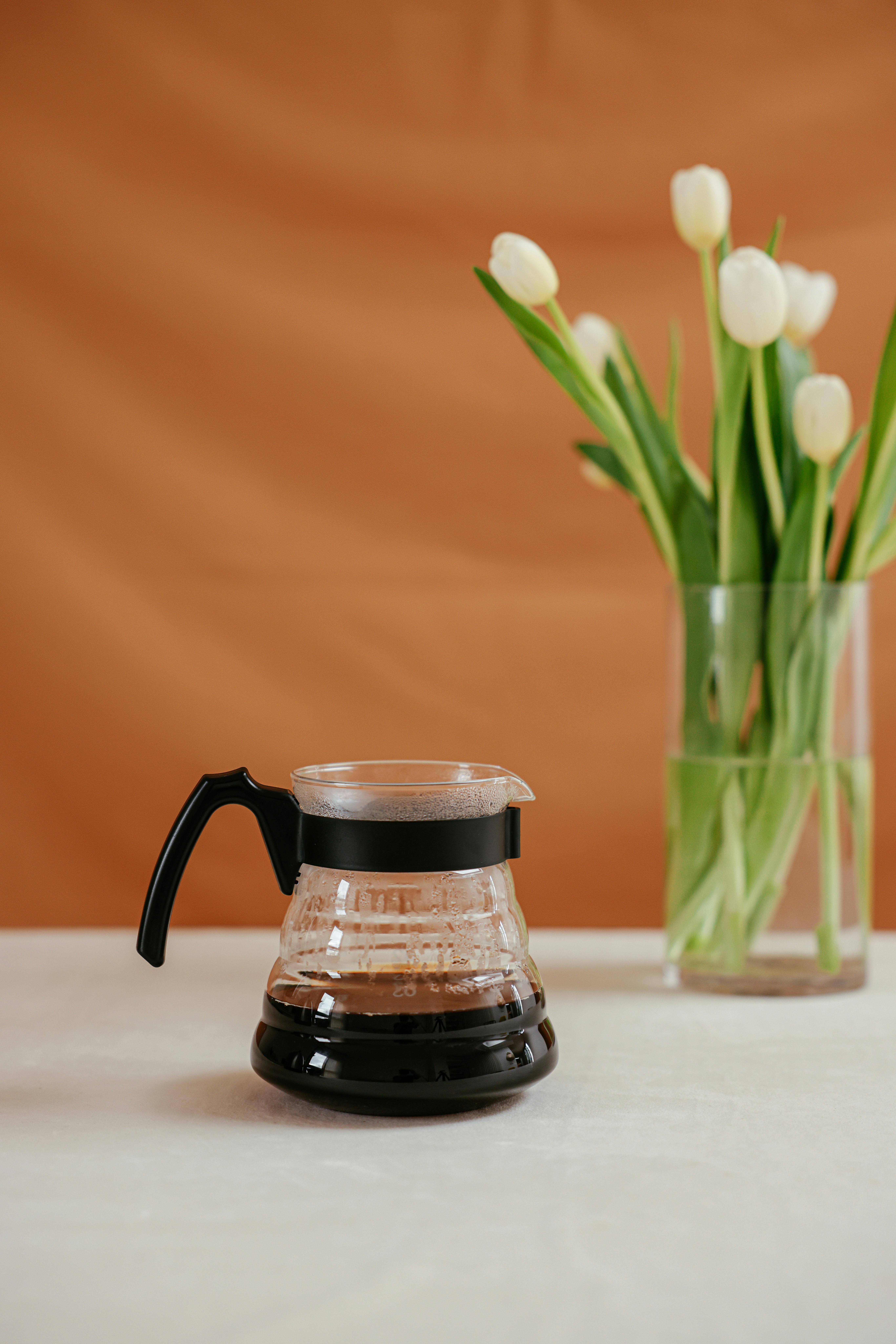 A Black Coffee in a Coffee Pot Beside a Vase with Flowers · Free Stock ...