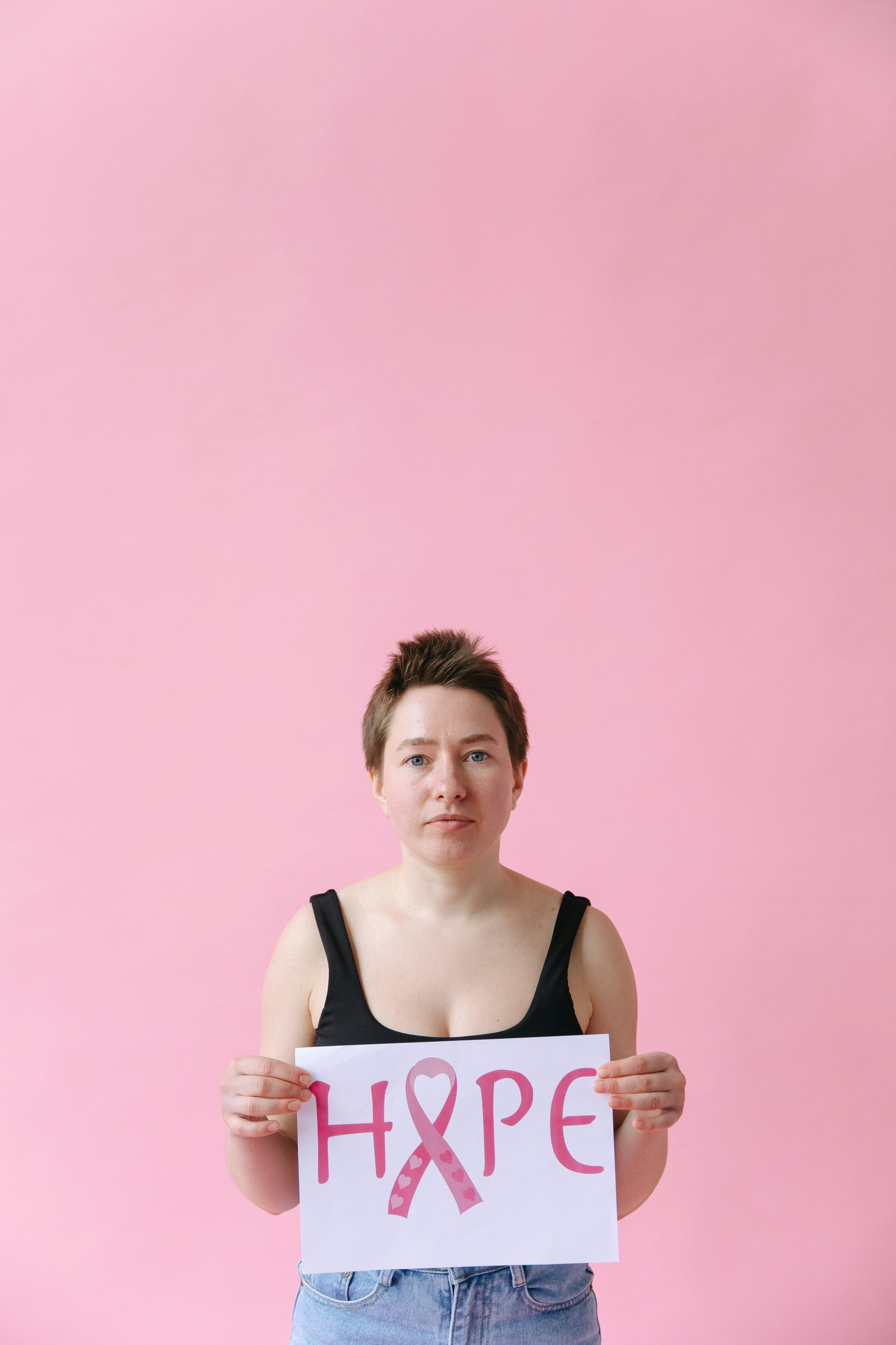 A Woman in Black Tank Top Holding a Hope Sign Symbol for Breast Cancer ...