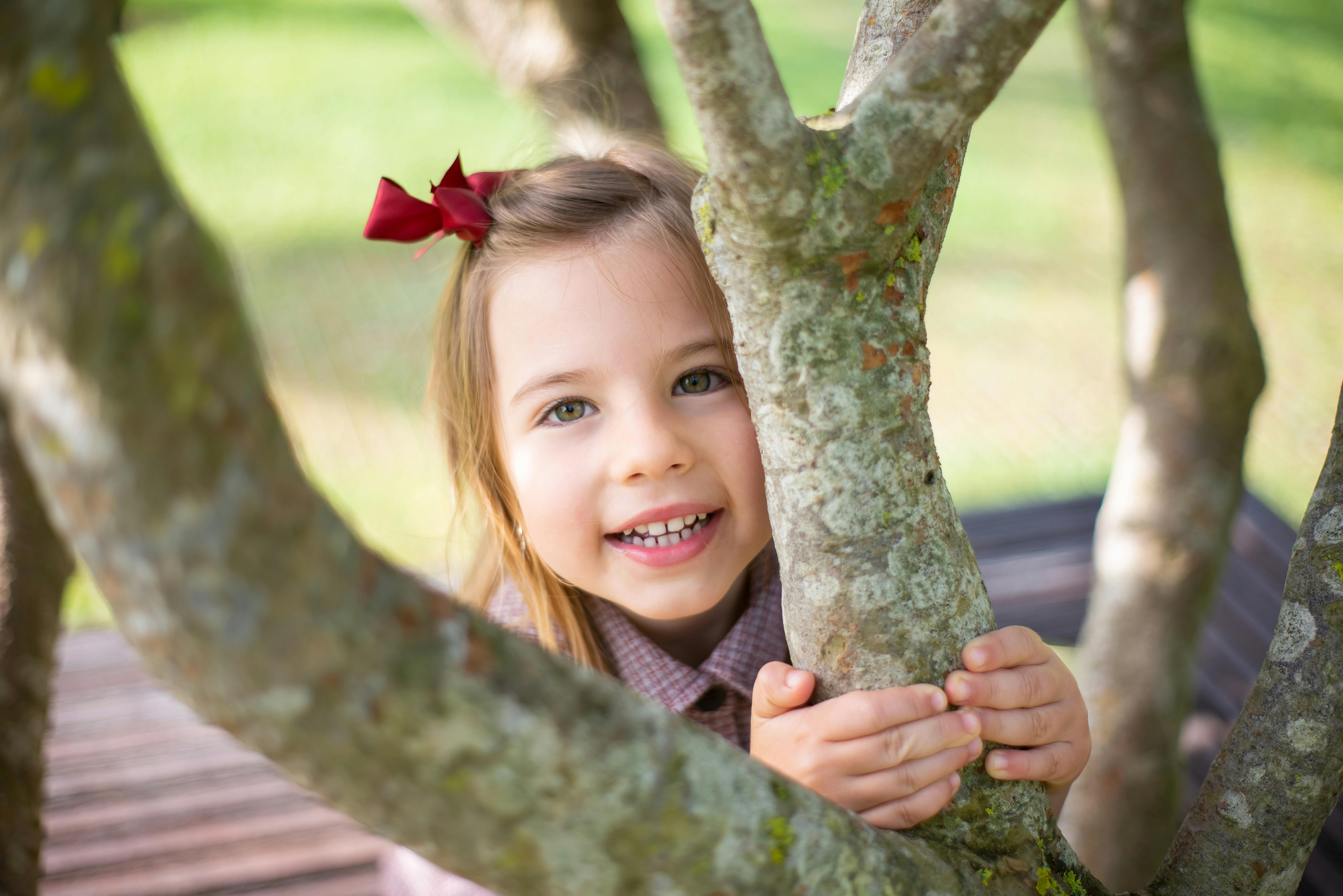 Smiling Girl Holding Tree Branches · Free Stock Photo