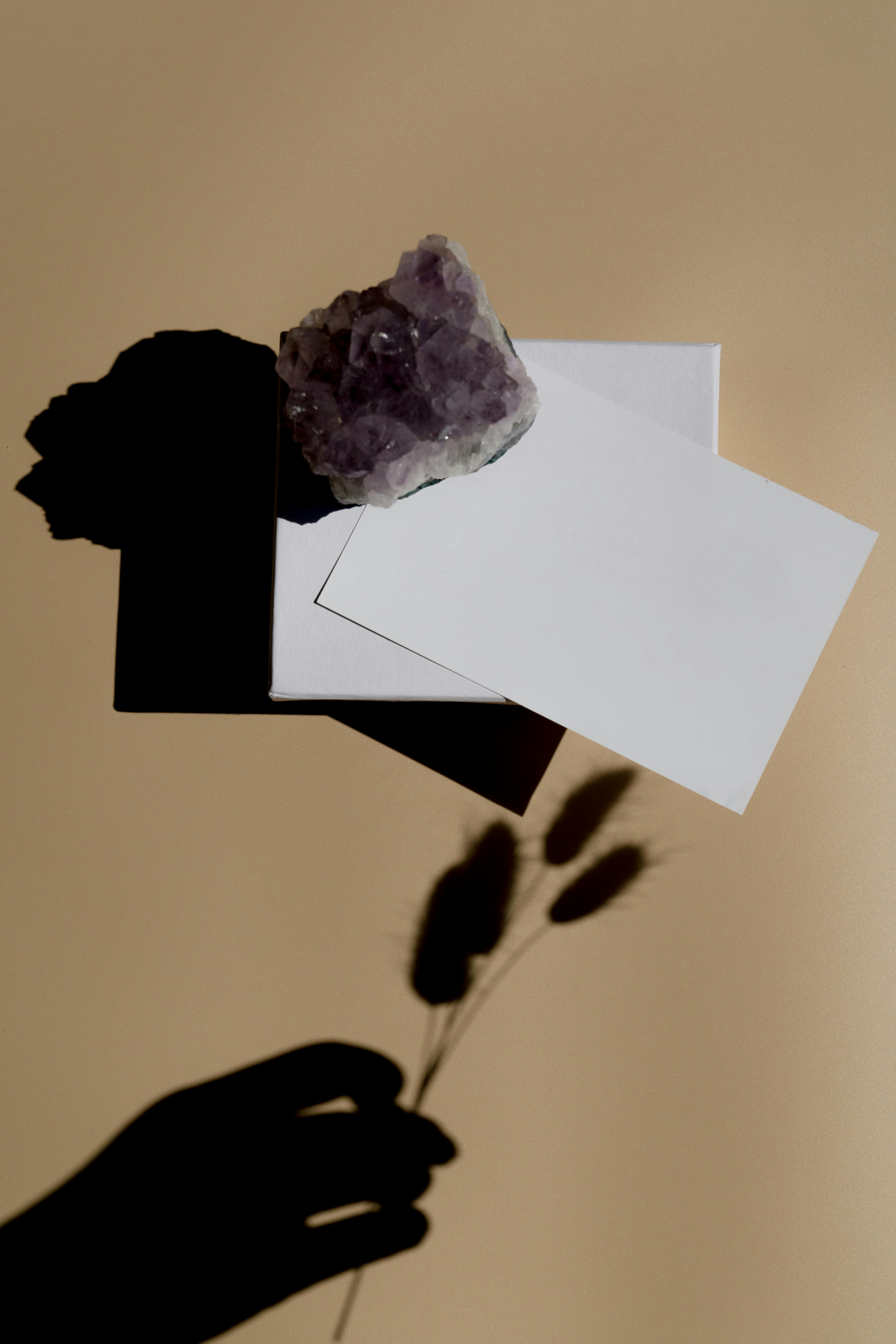 Shadow of Hand with Flowers over Papers and Gem · Free Stock Photo