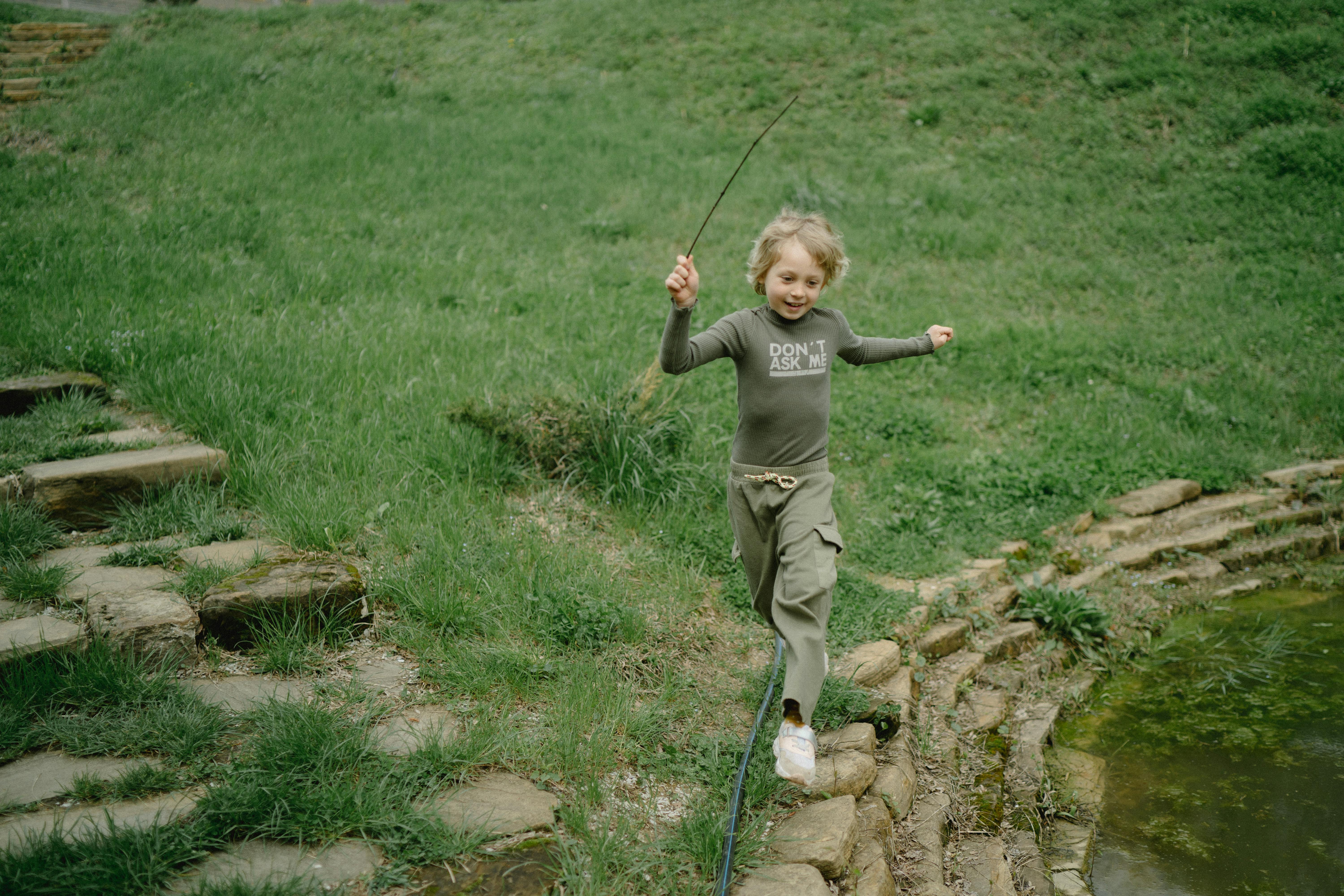 Boy in Gray Long Sleeve Shirt Running on Green Grass Field · Free Stock ...