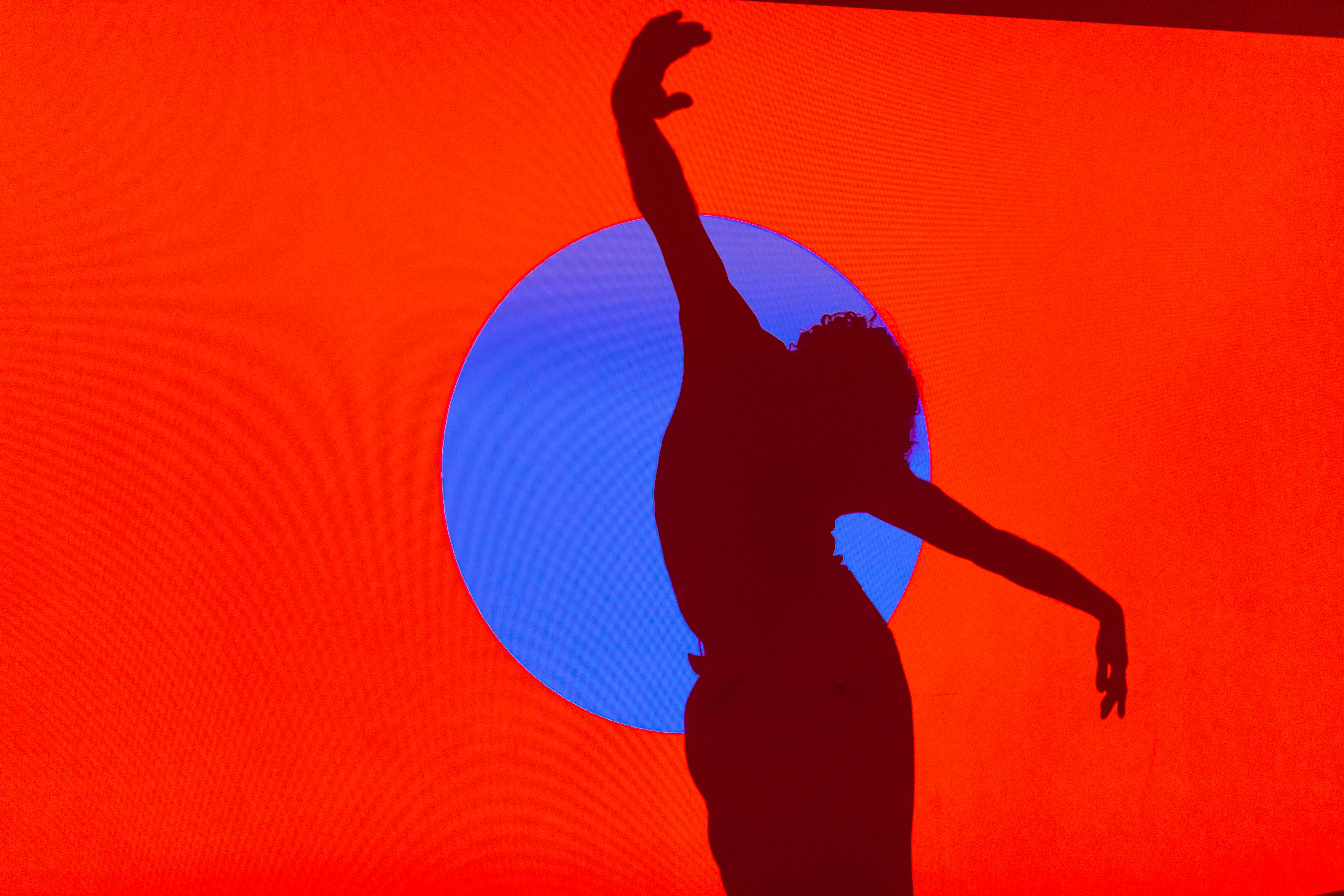 Silhouette Of A Person Dancing In Orange Background · Free Stock Photo