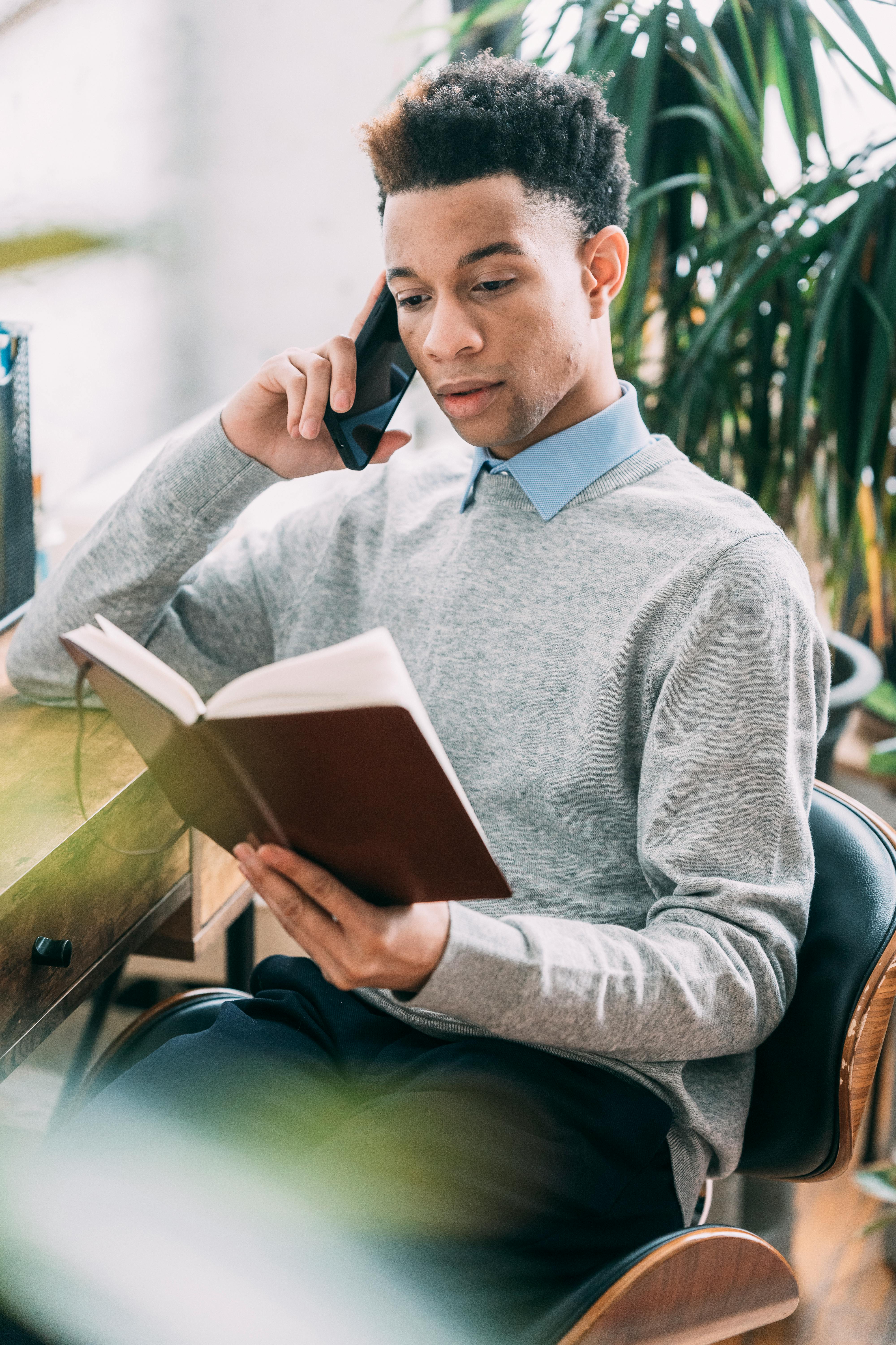 Man Having a Phone Call In-front of a Laptop · Free Stock Photo