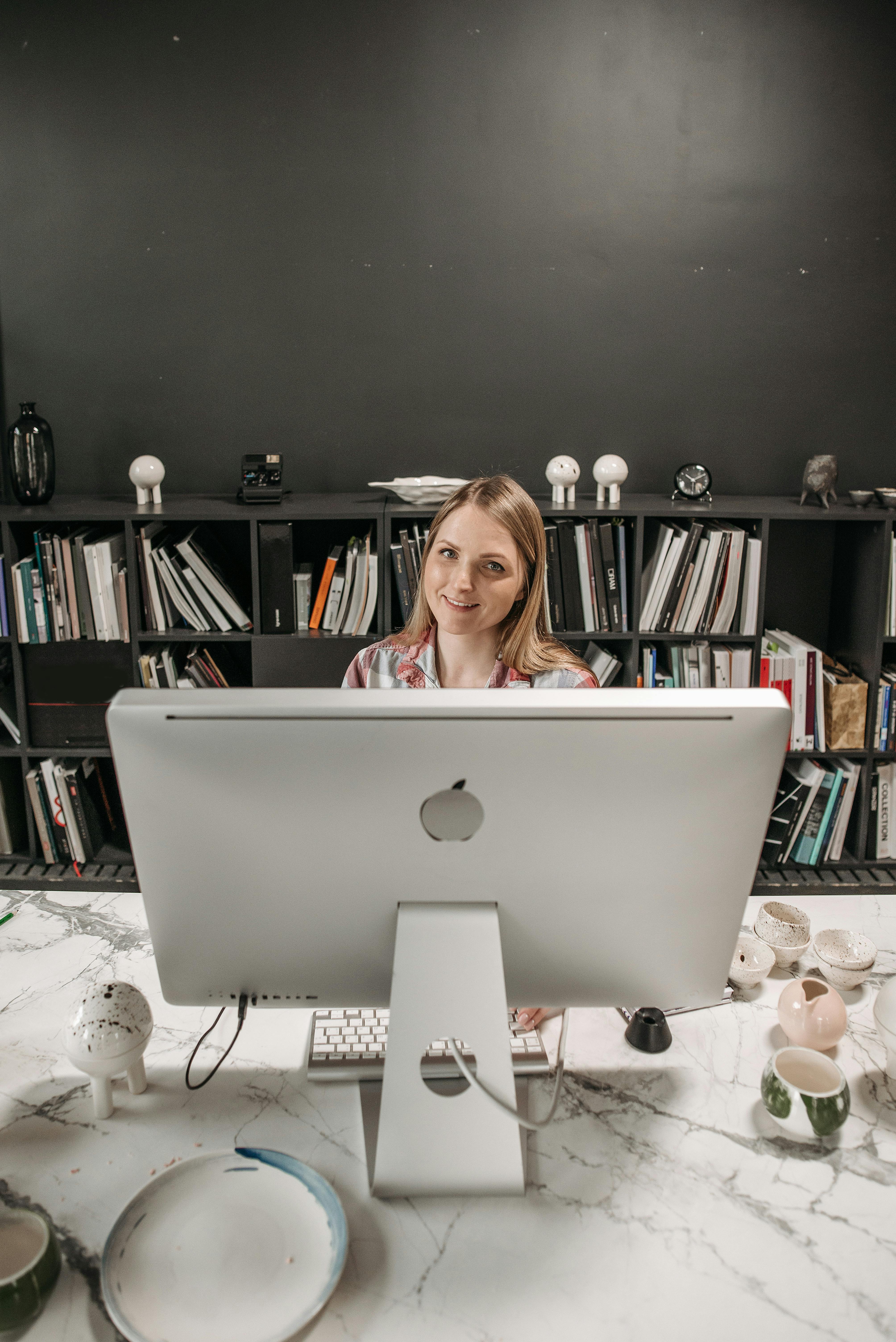 Smiling Woman Sitting in Front of a Computer · Free Stock Photo