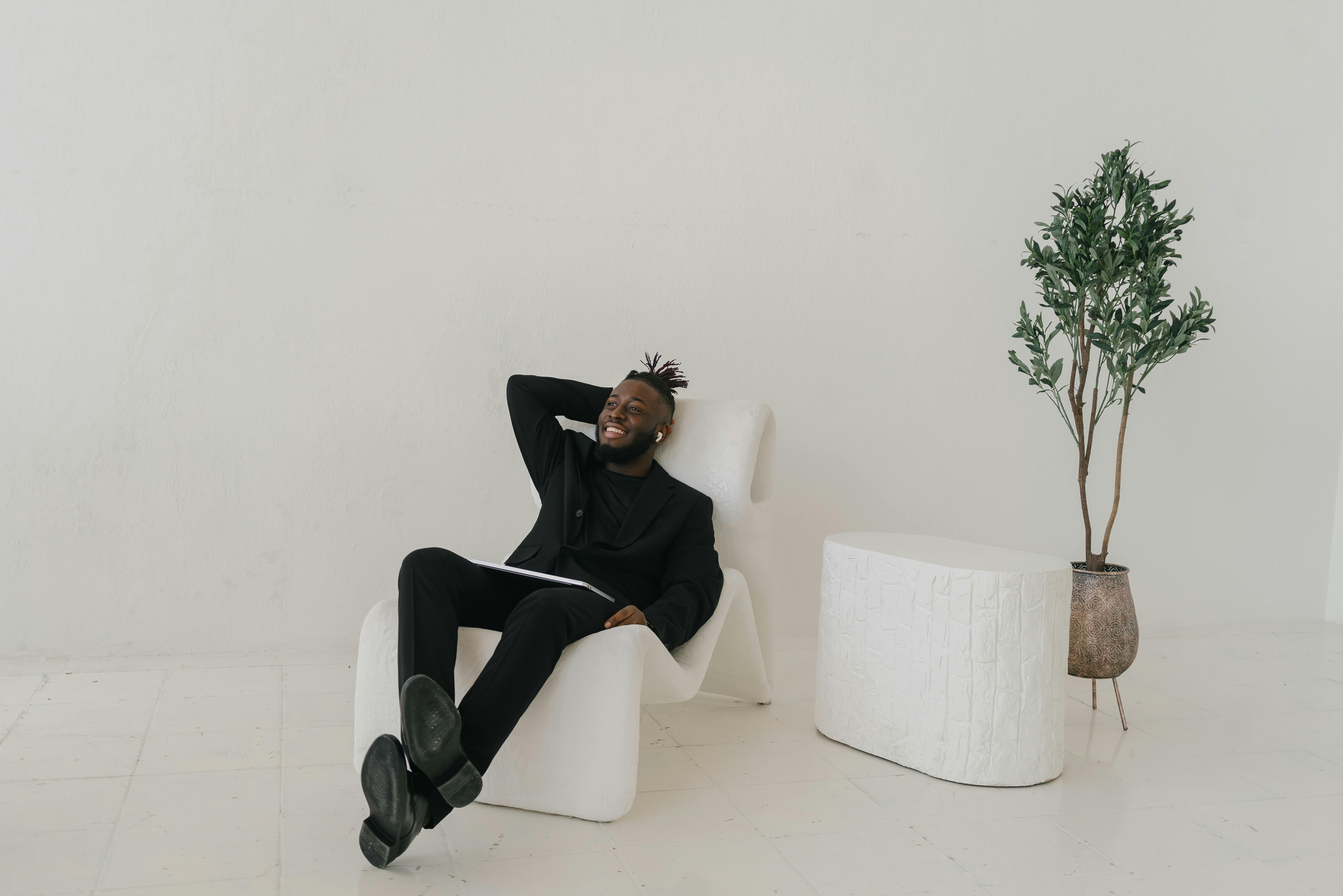 Man in Black Suit Relaxing on a White Lounge Chair · Free Stock Photo
