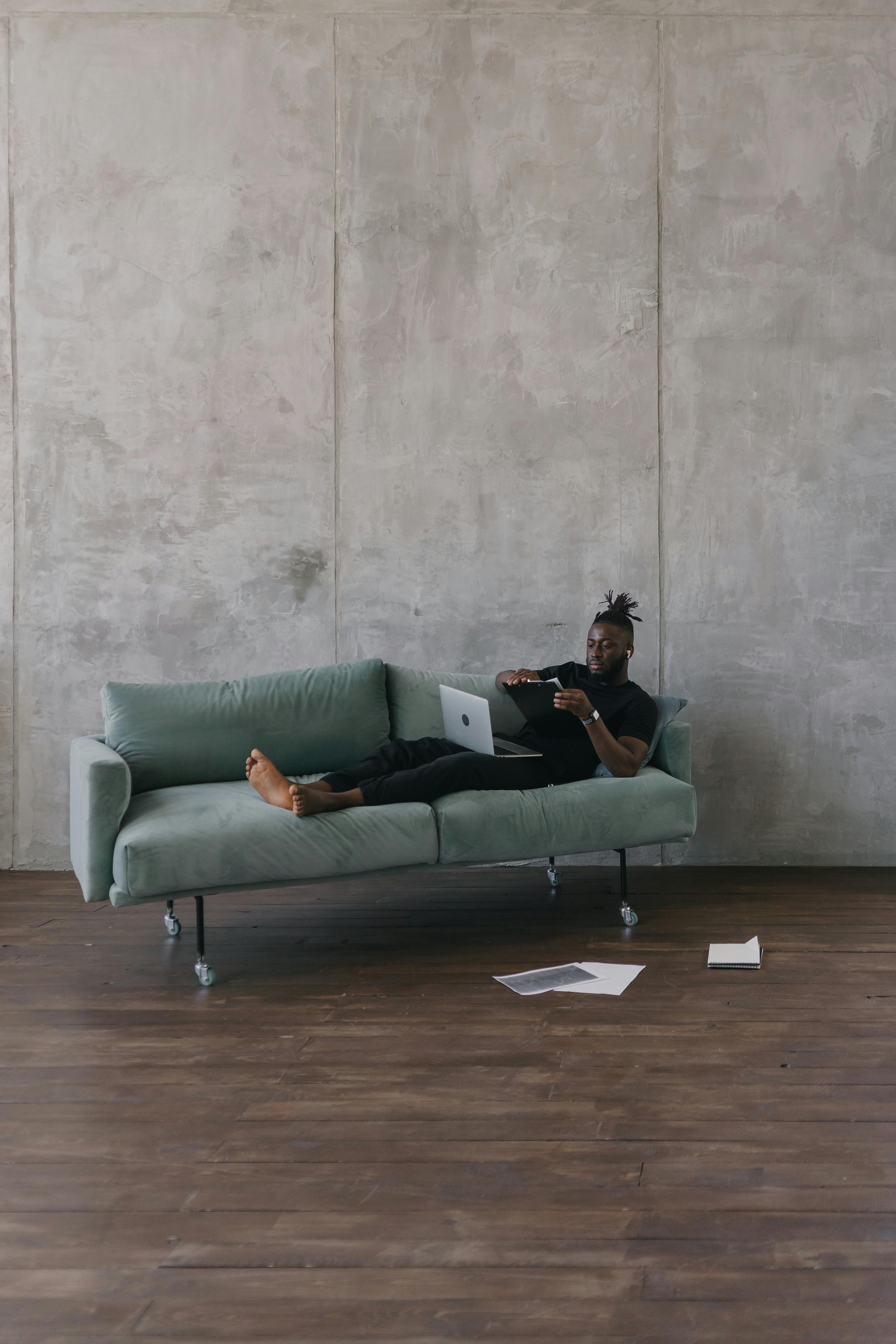 Man in Black Jacket Sitting on Gray Couch · Free Stock Photo