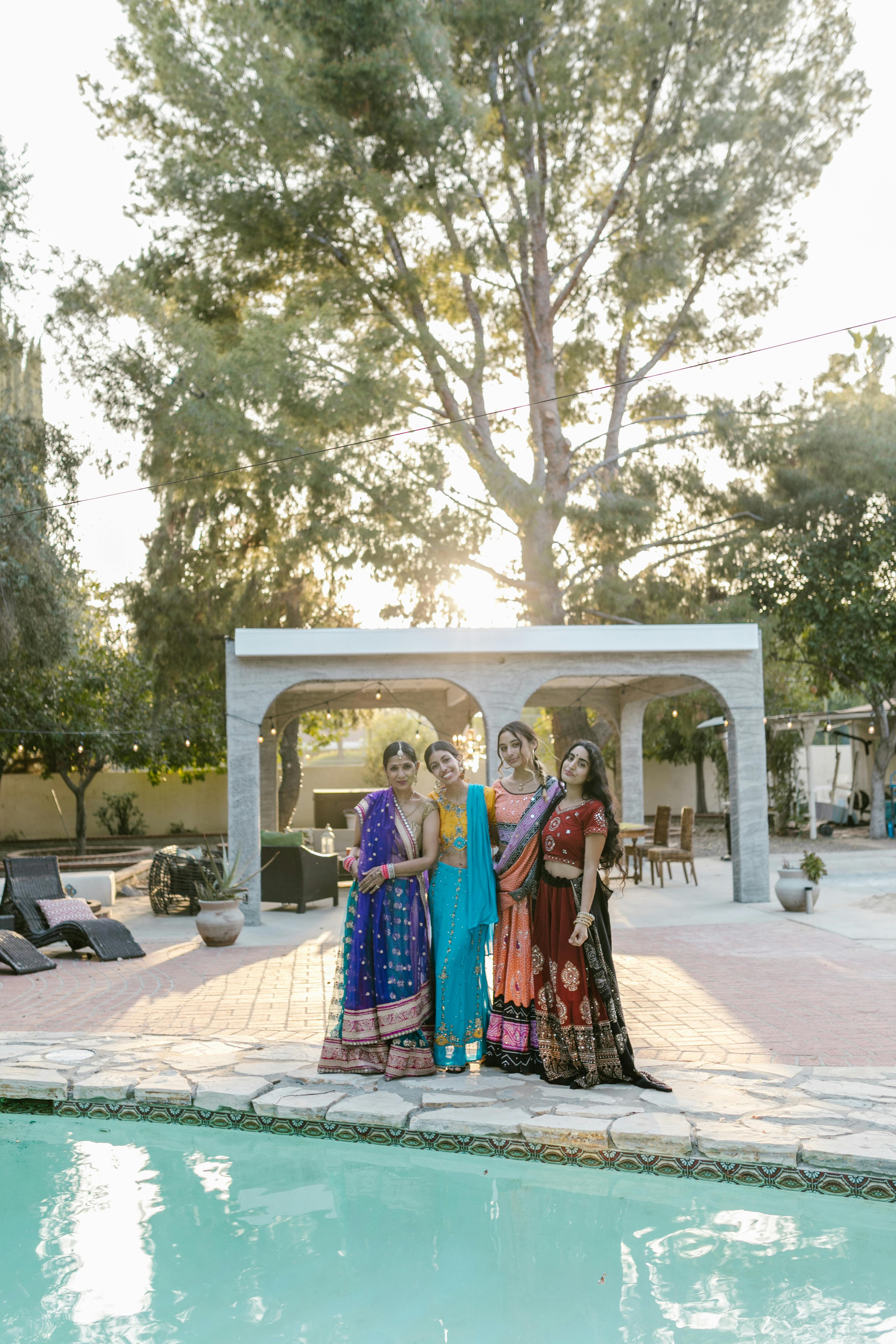 A Family in Traditional Clothing Posing by the Pool · Free Stock Photo