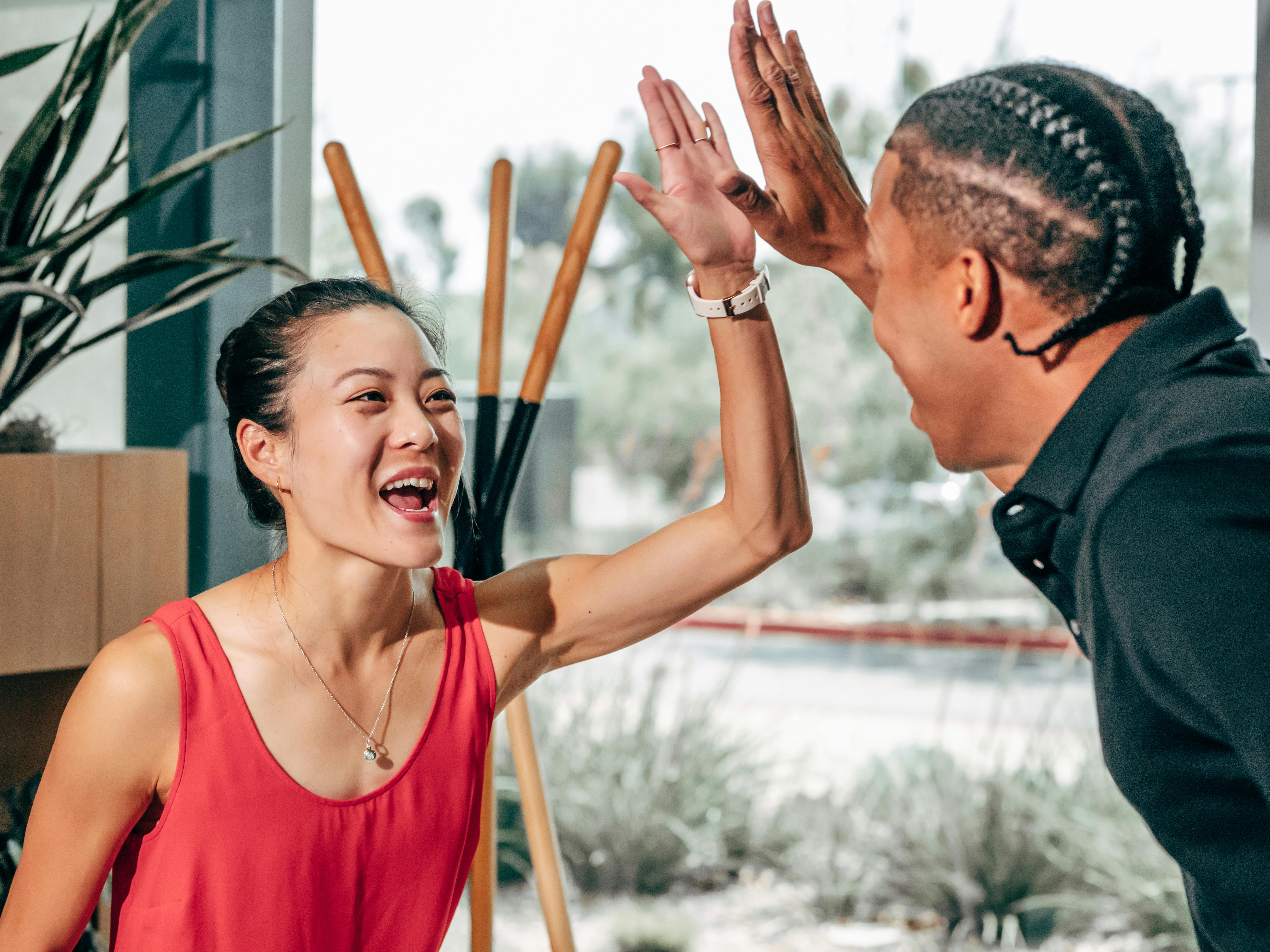 Man and Woman High Fiving · Free Stock Photo