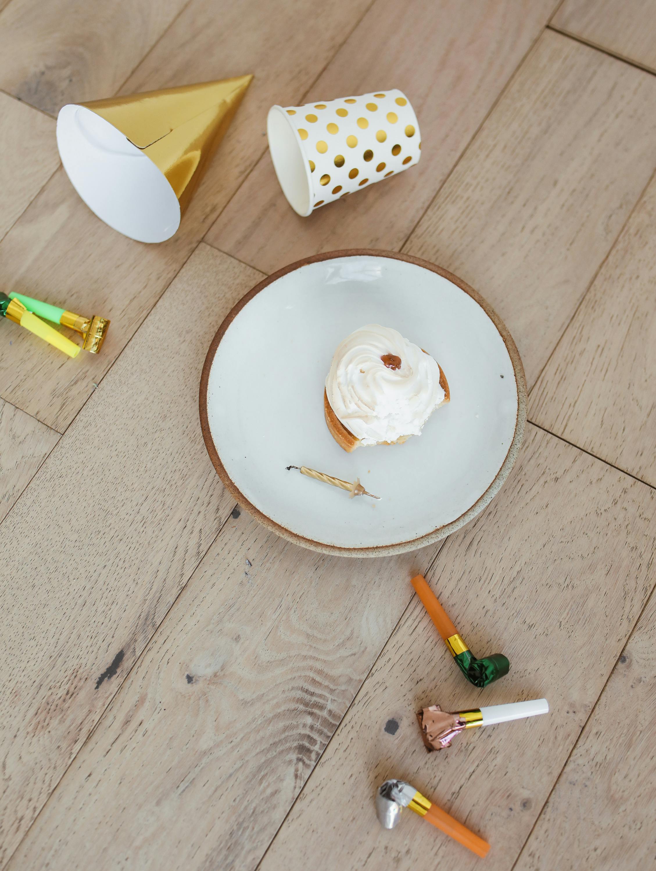 Party Whistles and Cap around Cake on Plate · Free Stock Photo