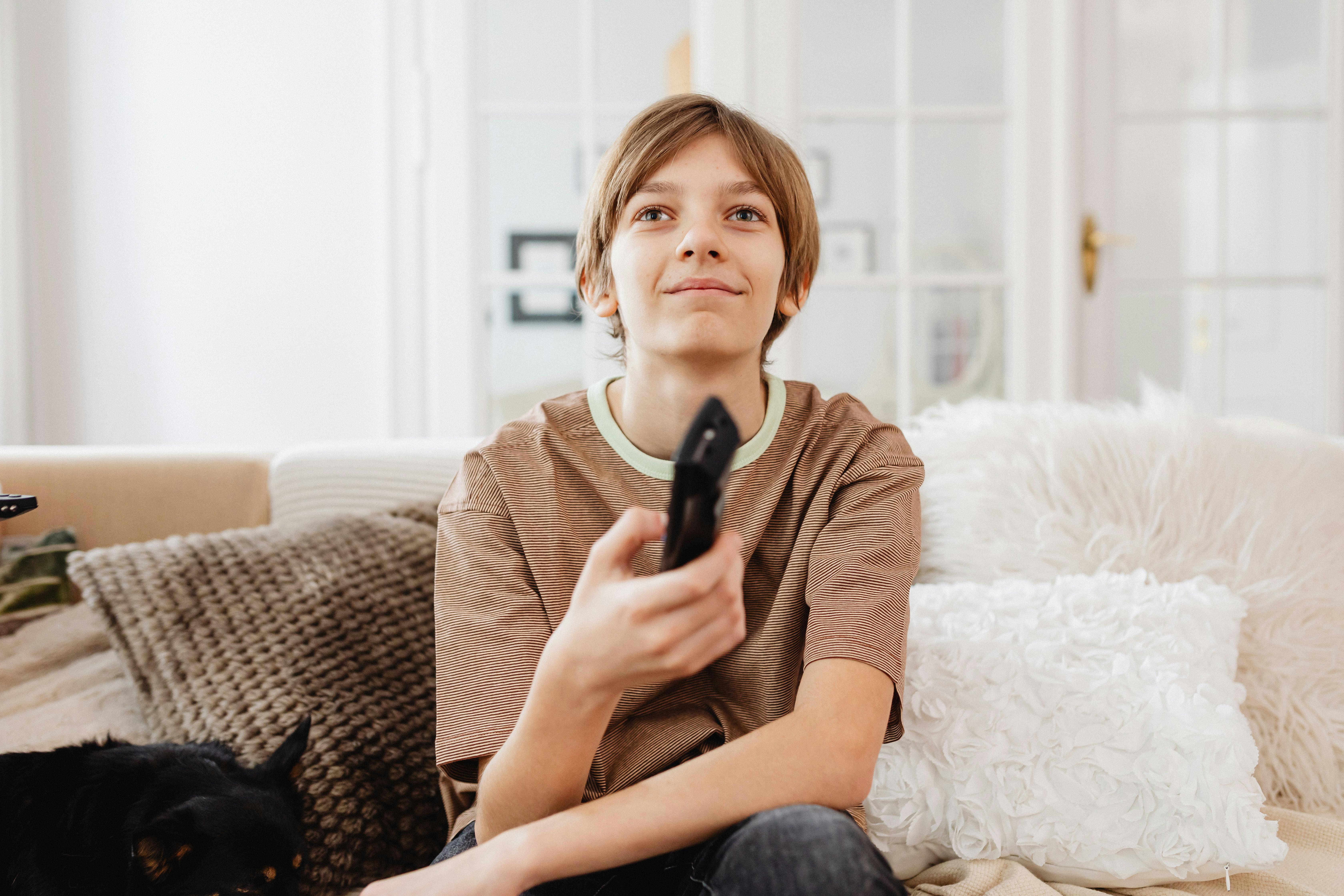 A Boy Holding a TV Remote · Free Stock Photo