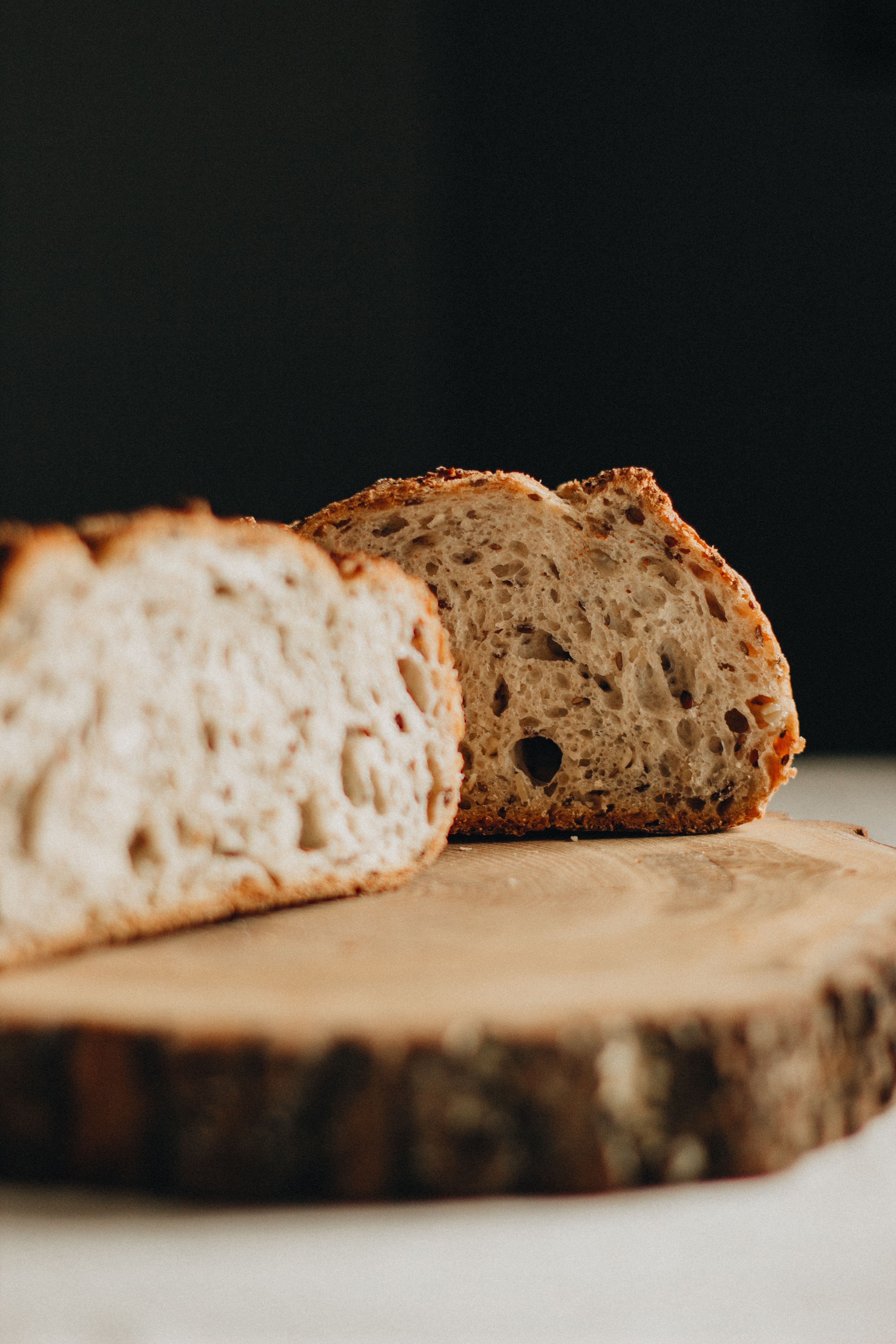 Crop unrecognizable person showing fresh cut bread · Free Stock Photo